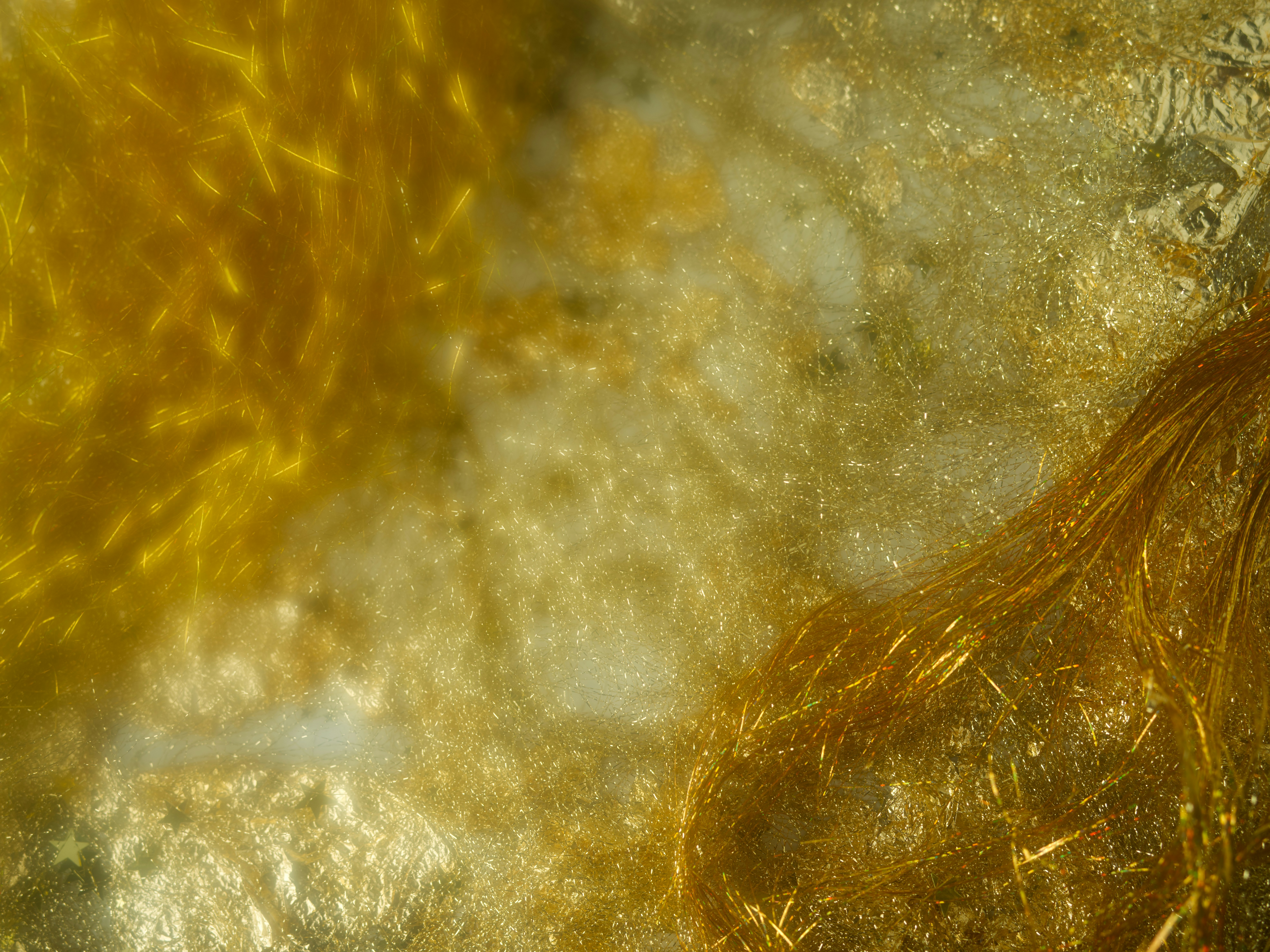 Close up abstract texture of golden fibers and white material.