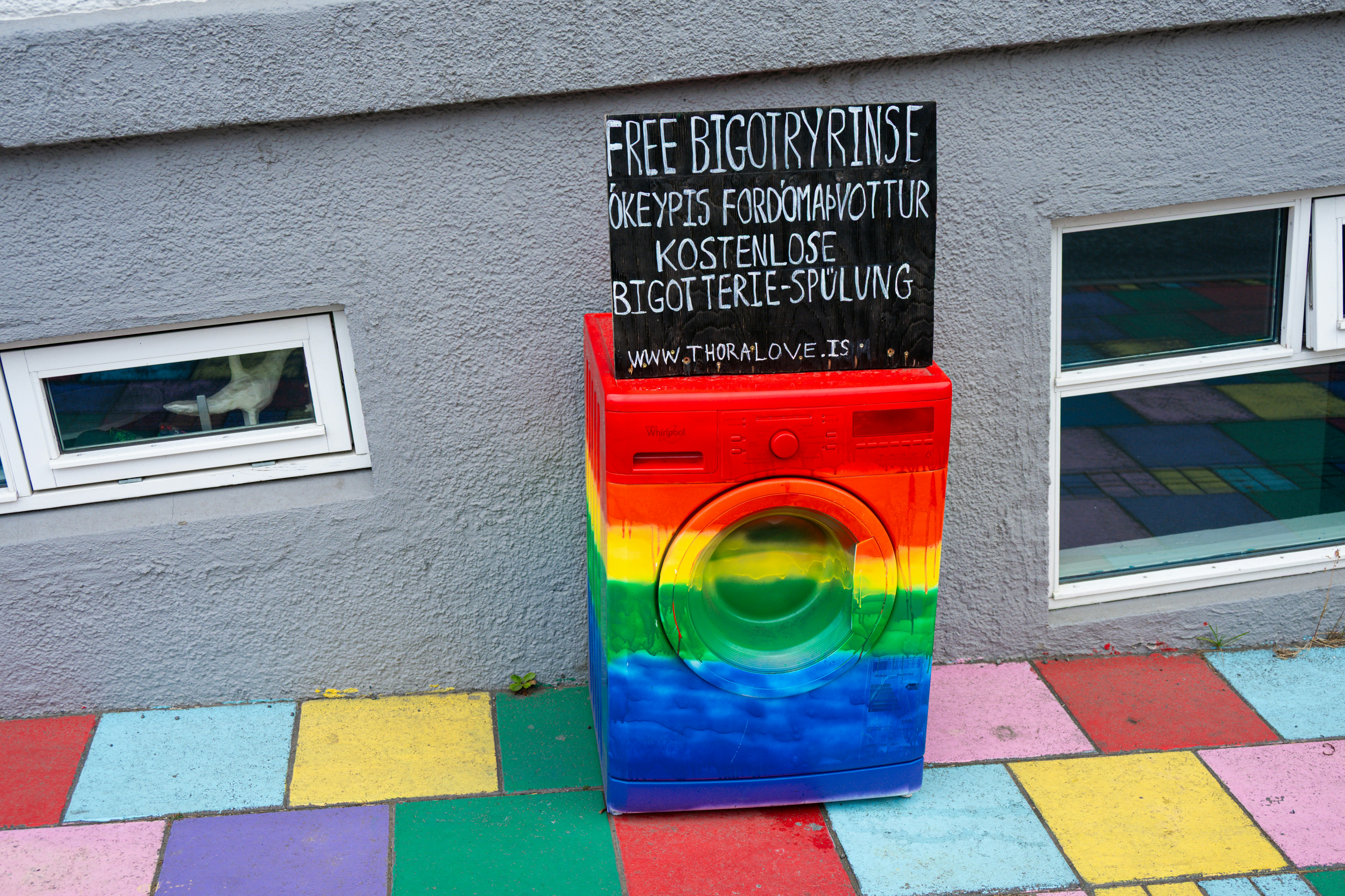 Rainbow painted washing machine with sign
