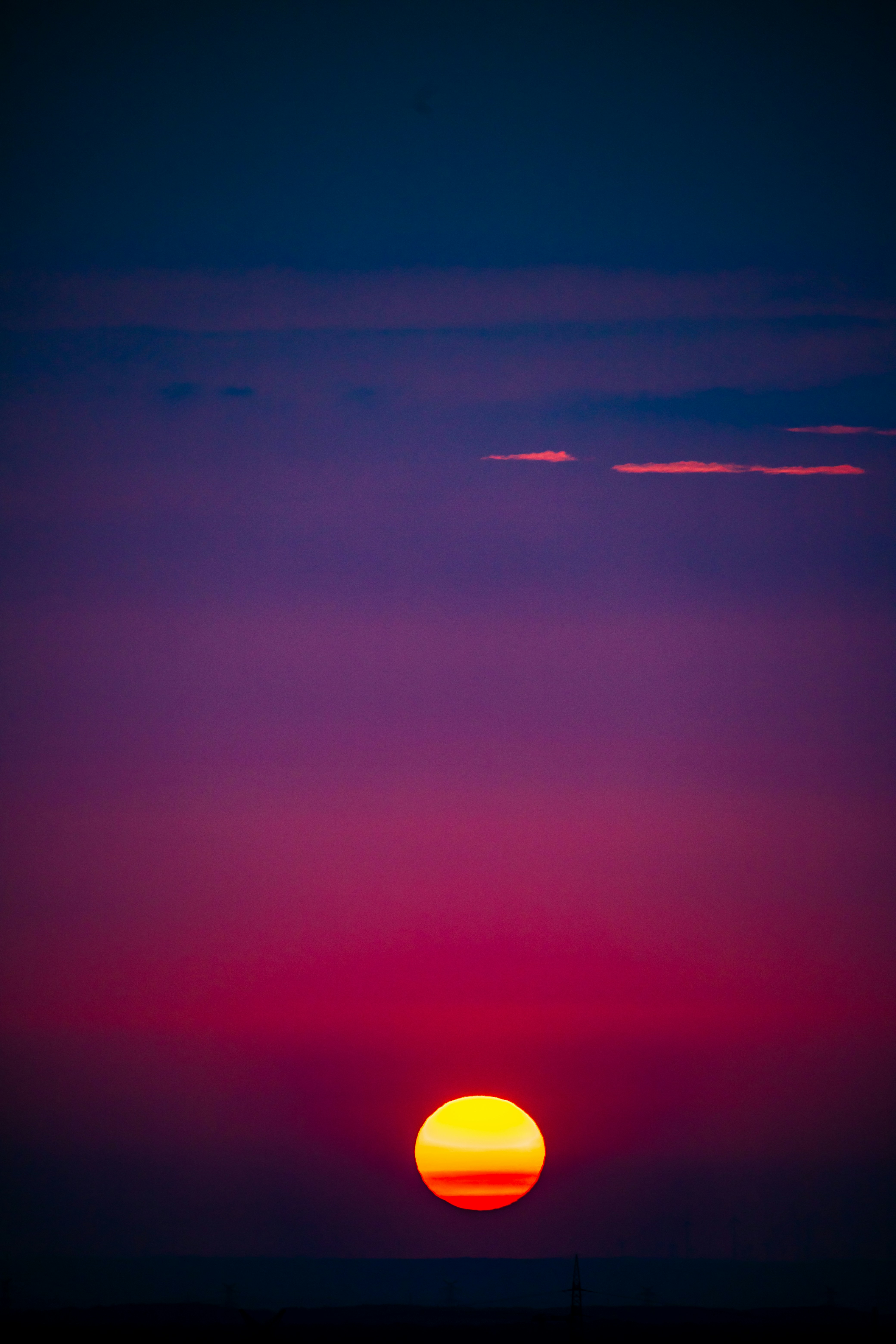 Vibrant sunset with a bright orange sun and purple sky