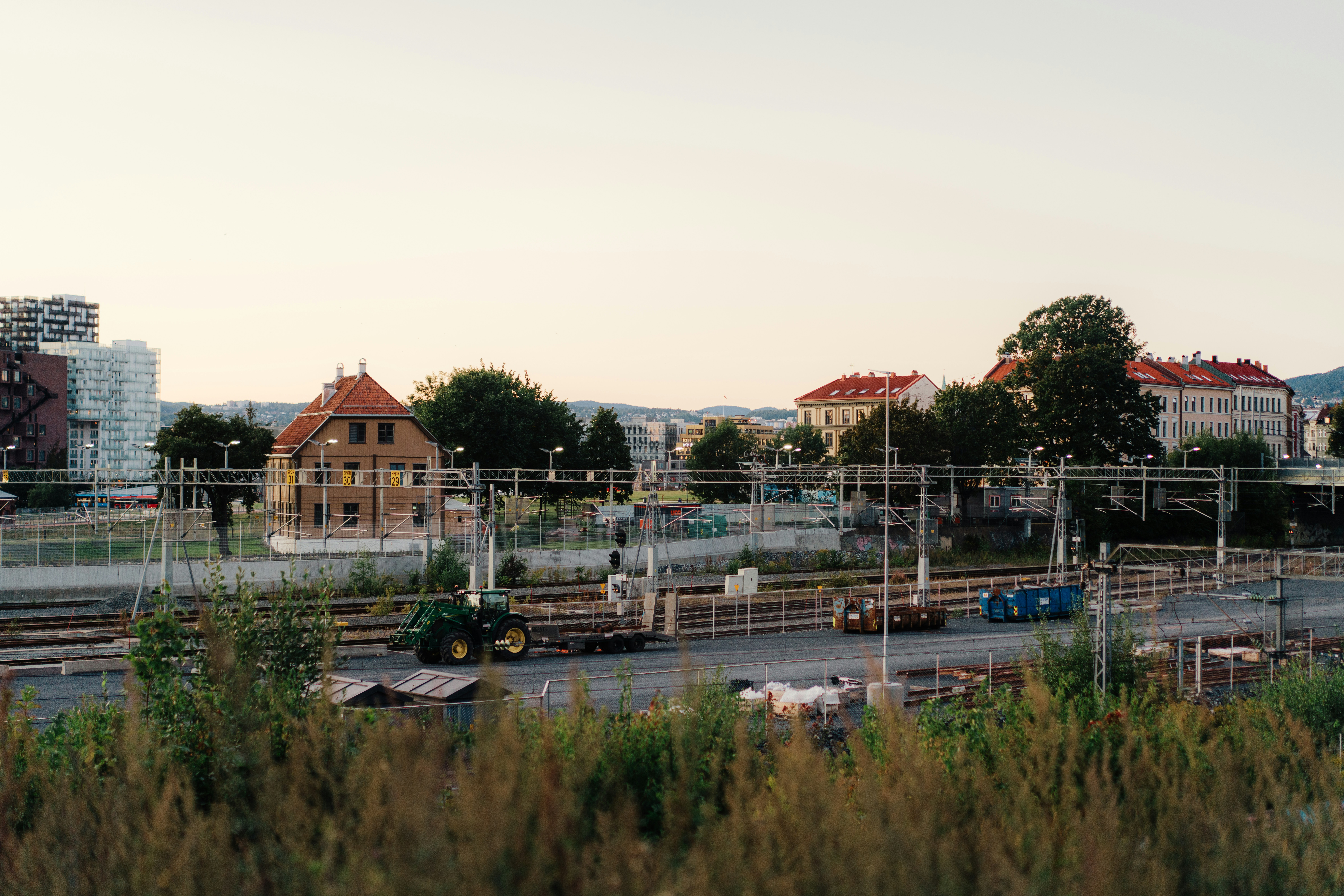 Train tracks with buildings and trees in background
