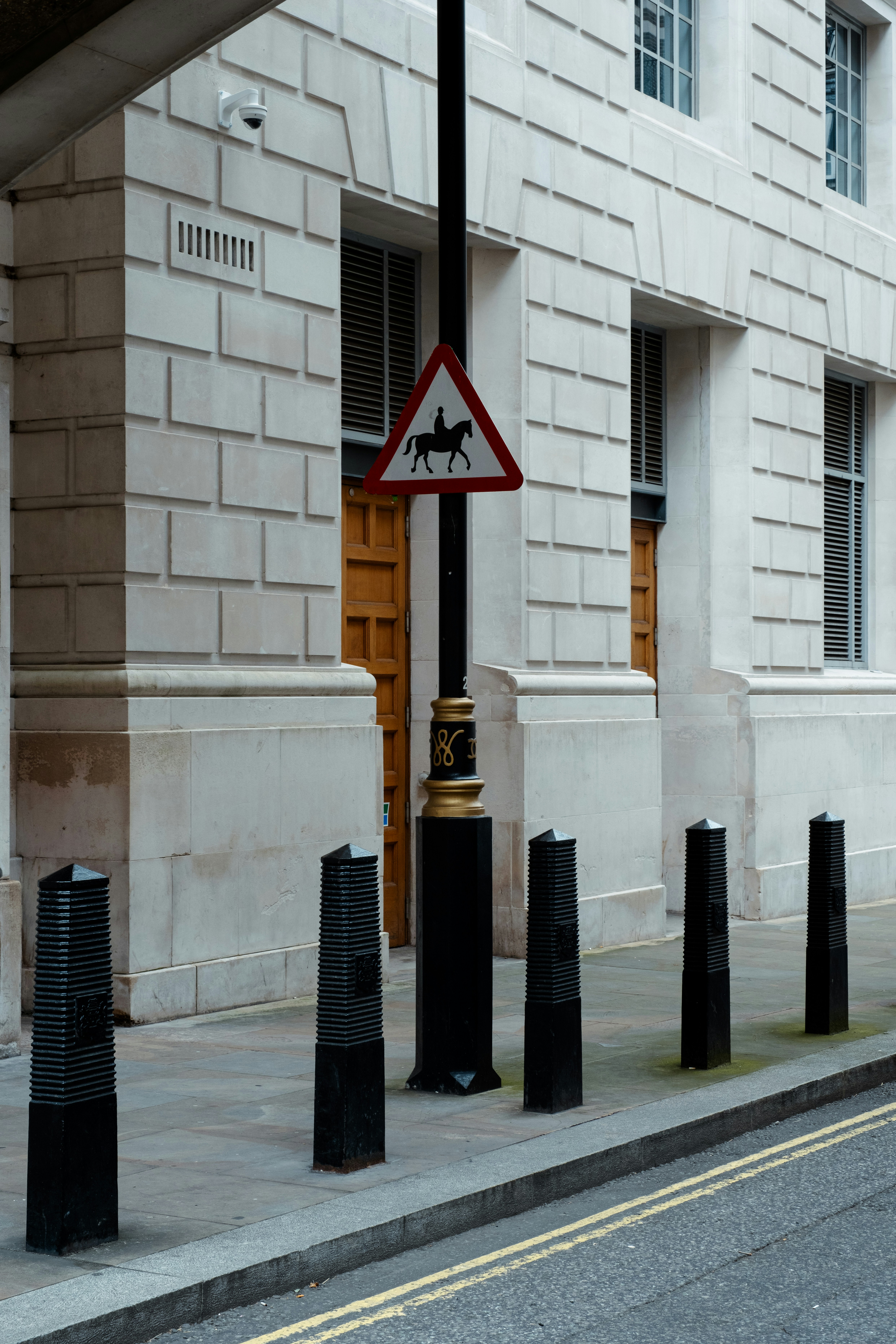 Street sign warns of horses near building