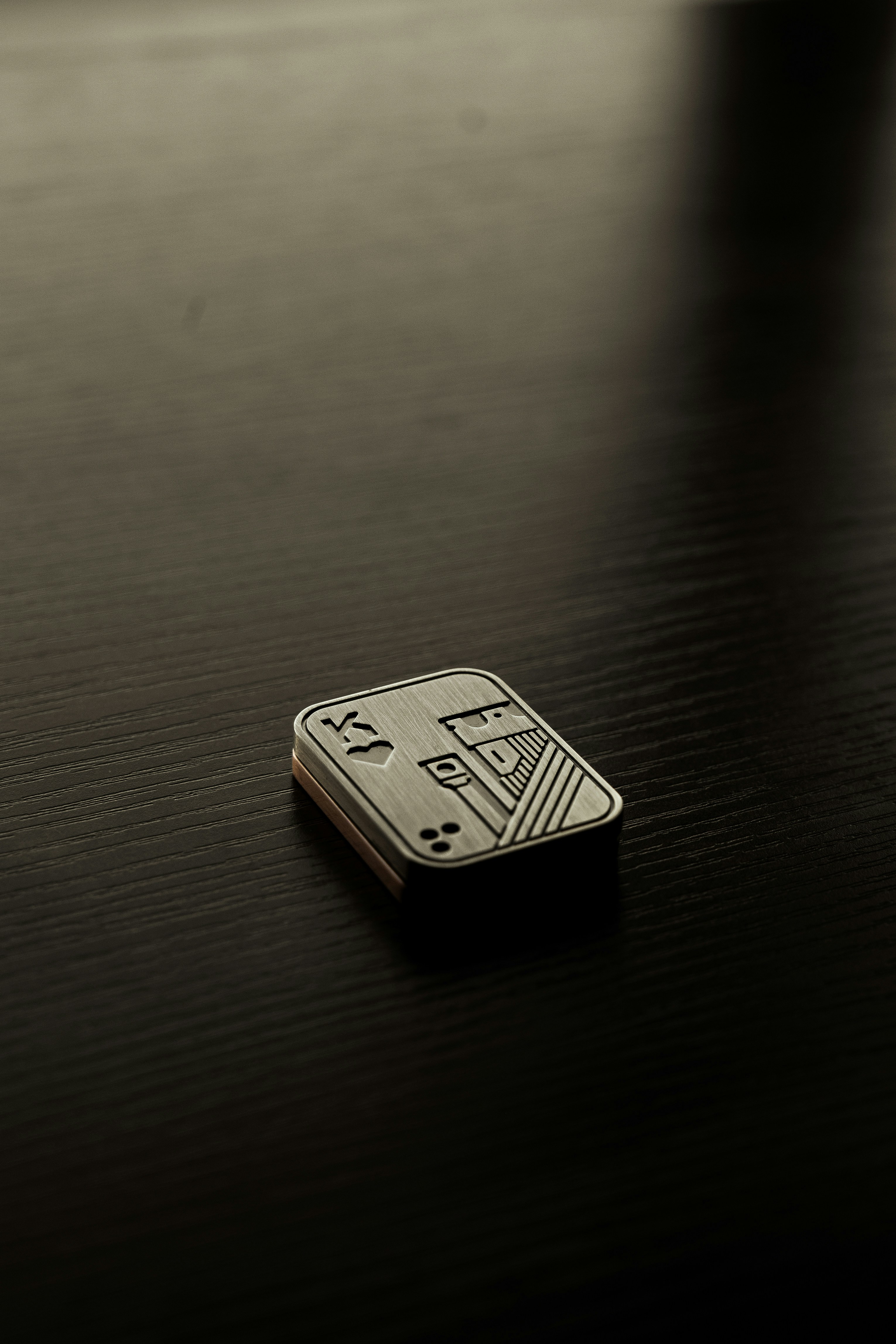 Loved capturing this moment 📸. If you enjoy minimal photography, check out my guide here: https://quietminimalism.etsy.com/listing/4347811015 | Small metal tin with engraved design on dark surface