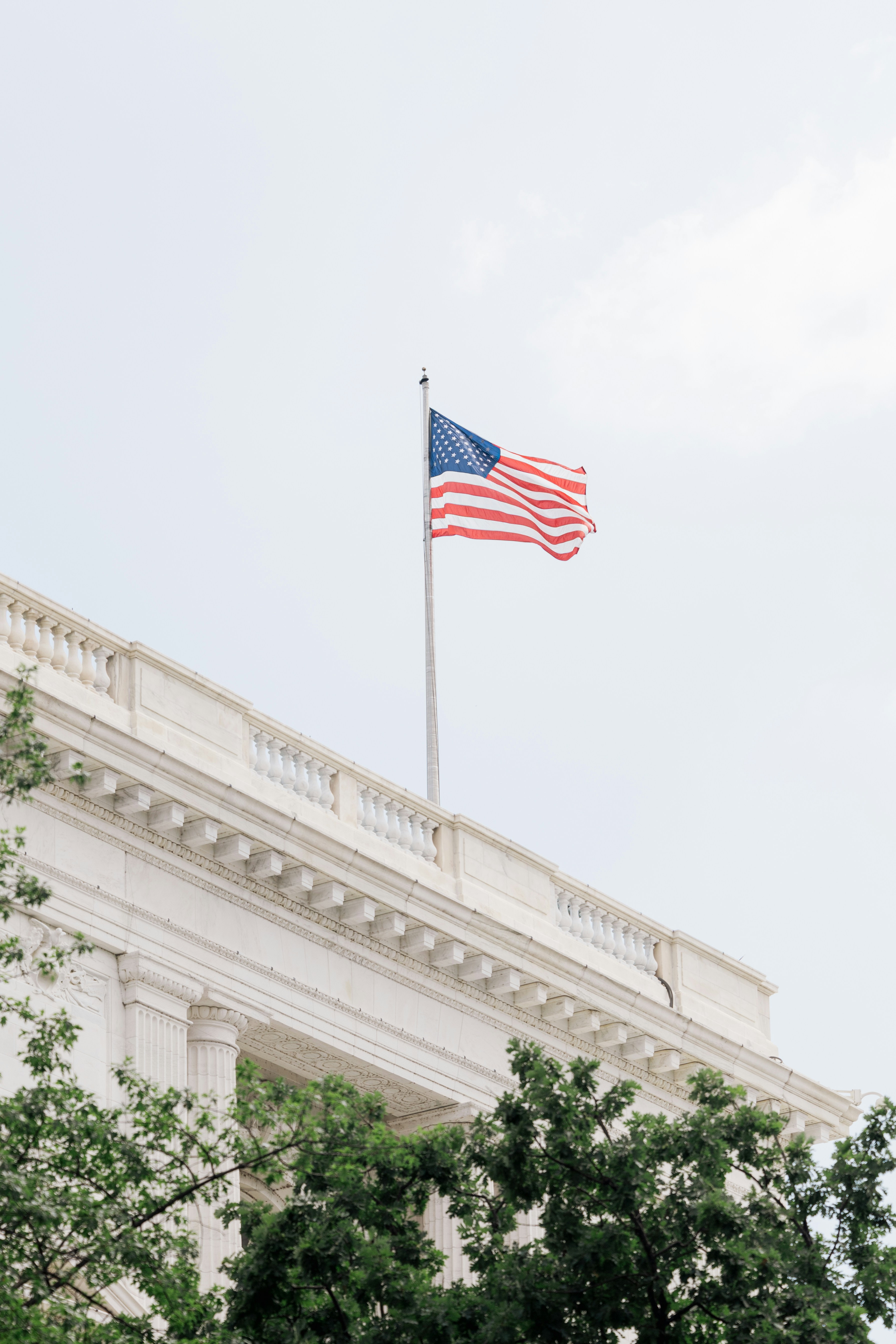 American flag waves atop a white building.