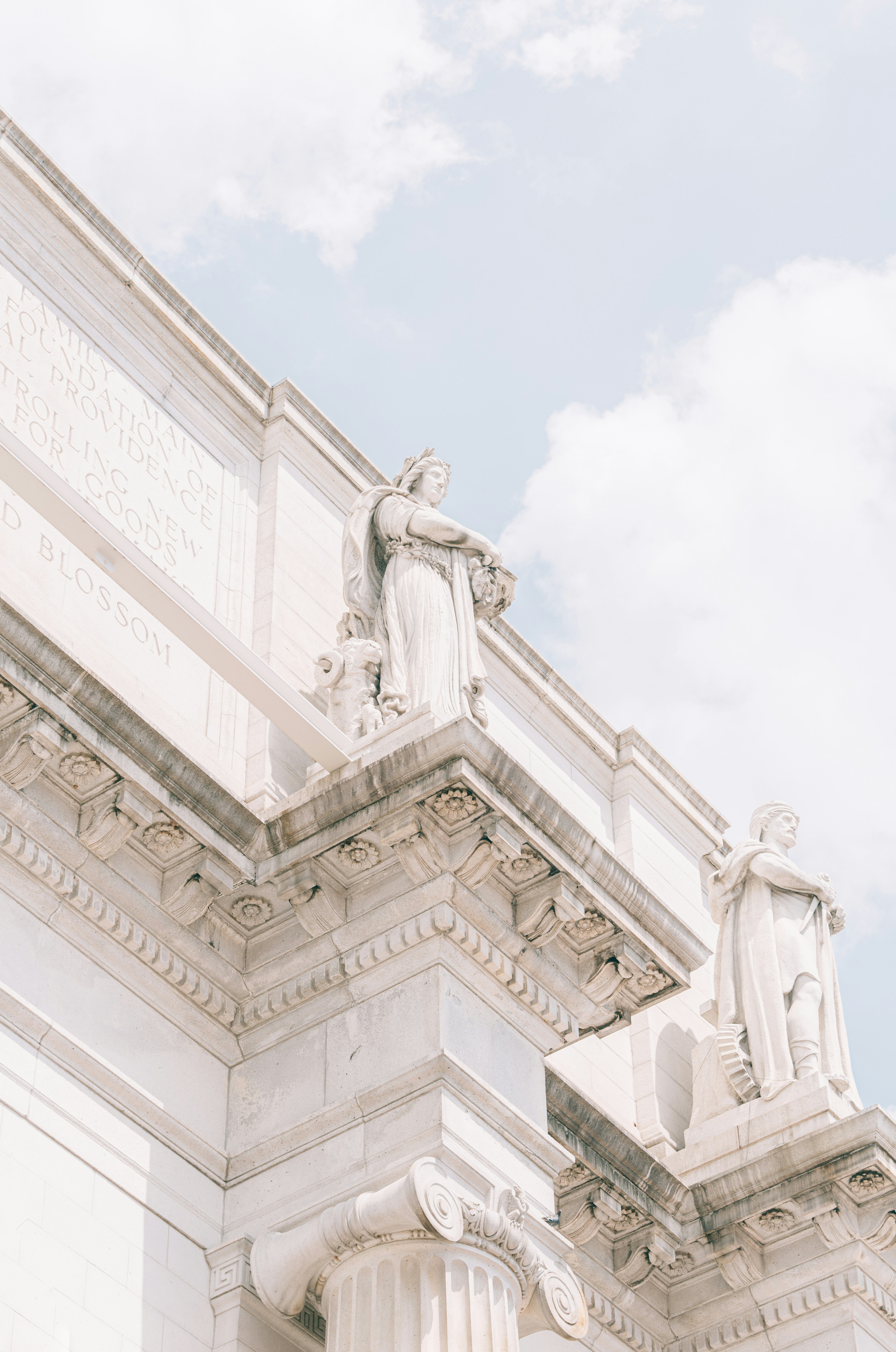 Classical architecture with statues against a cloudy sky
