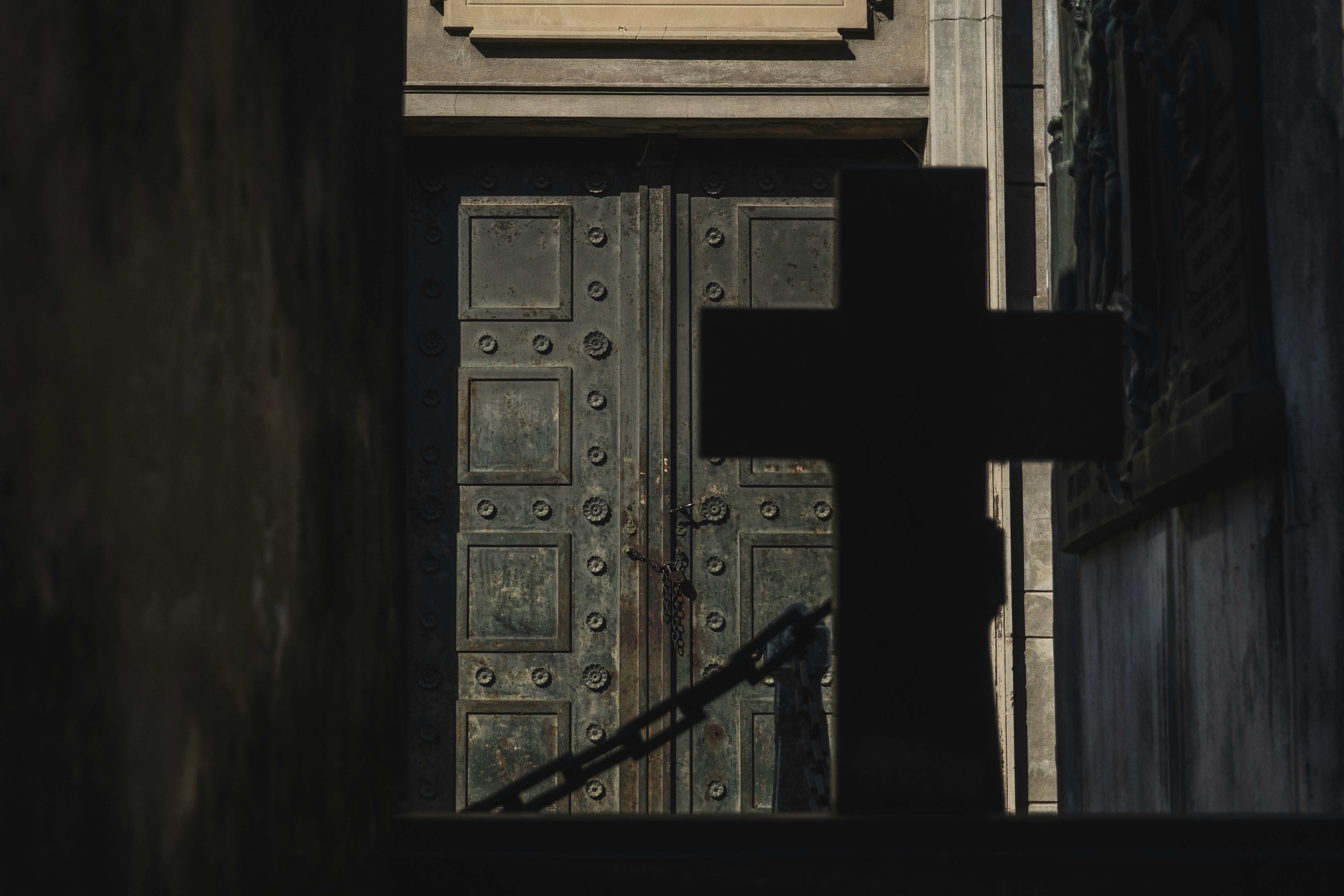 Ornate doors and cross in a dark mausoleum