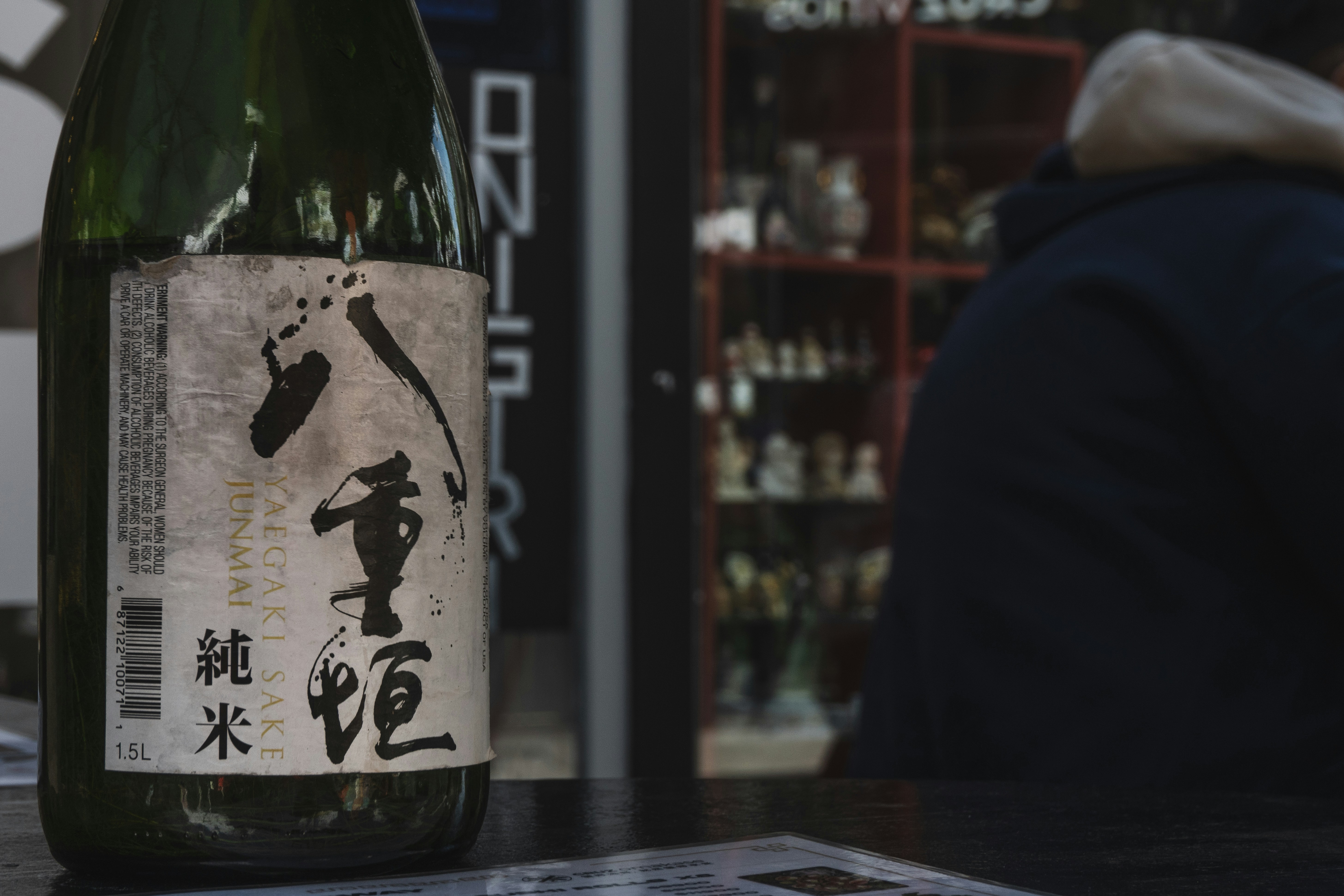 Liquid Culture: A Bottle of Japanese Sake Anchored by a Dim City Scene