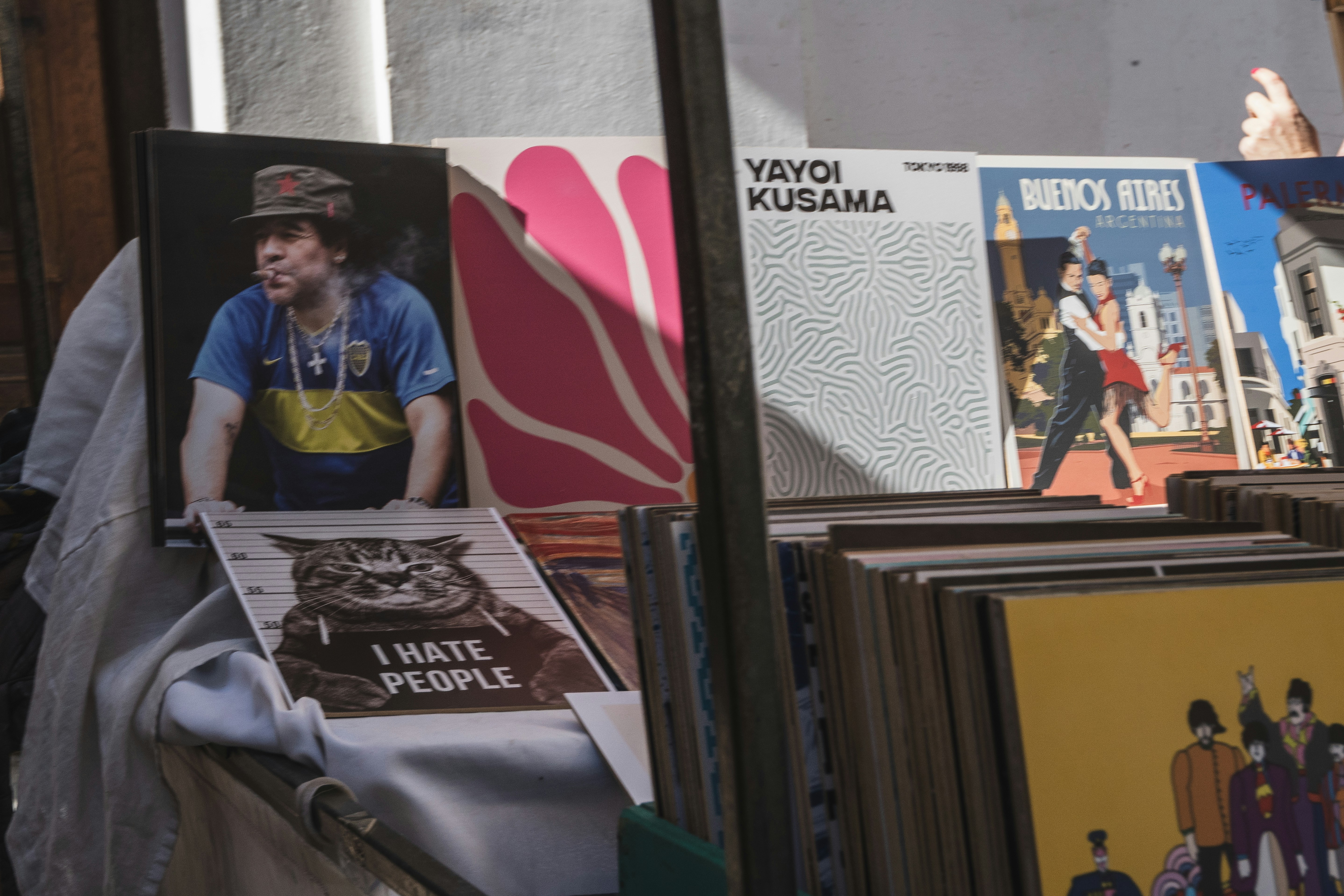 A vibrant display of vinyl records featuring diverse album covers, including a portrait of a man wearing a sports jersey and a bold statement piece. 