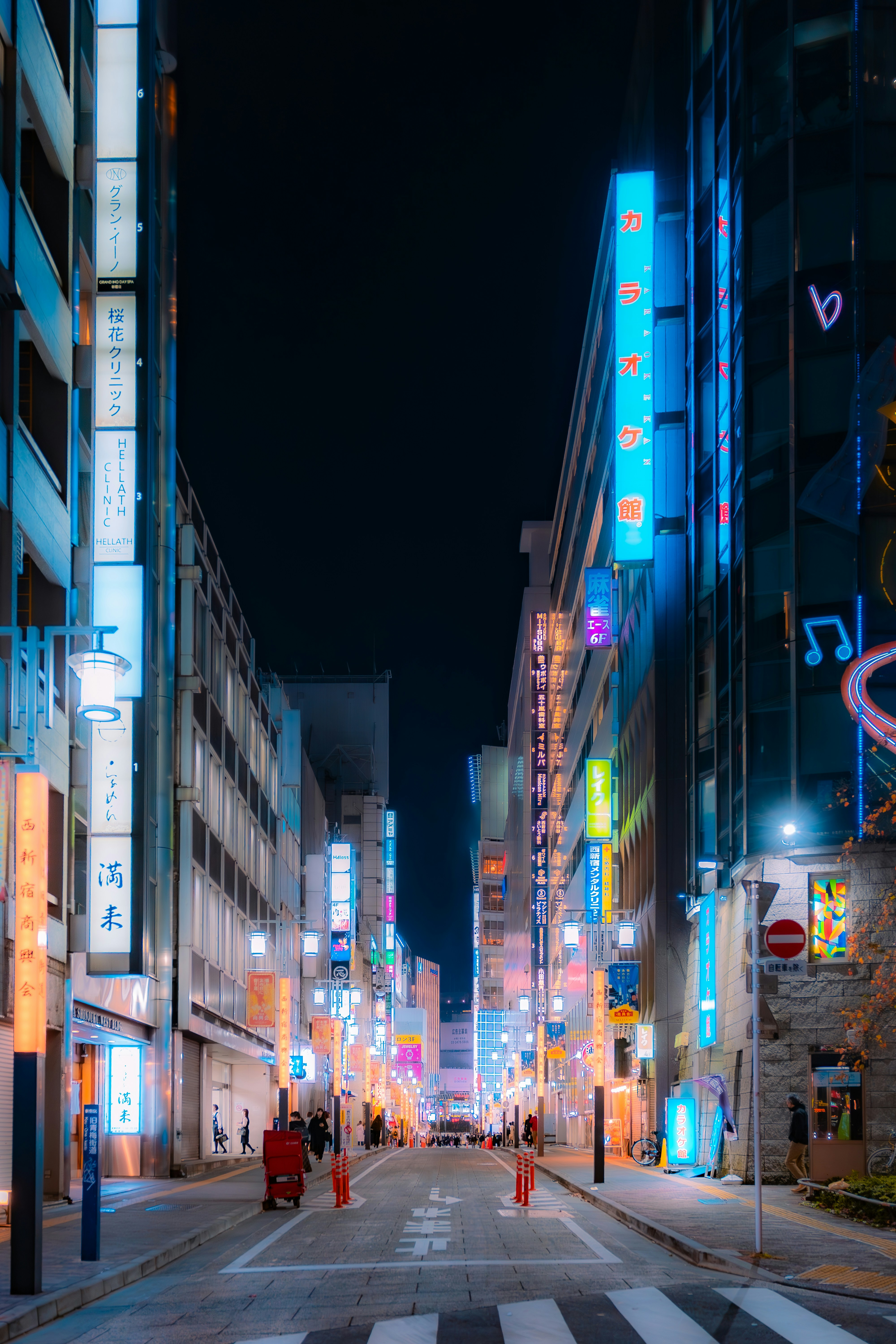 Vibrant street scene illuminated by neon signs and soft street lighting, showcasing a lively urban atmosphere at night.