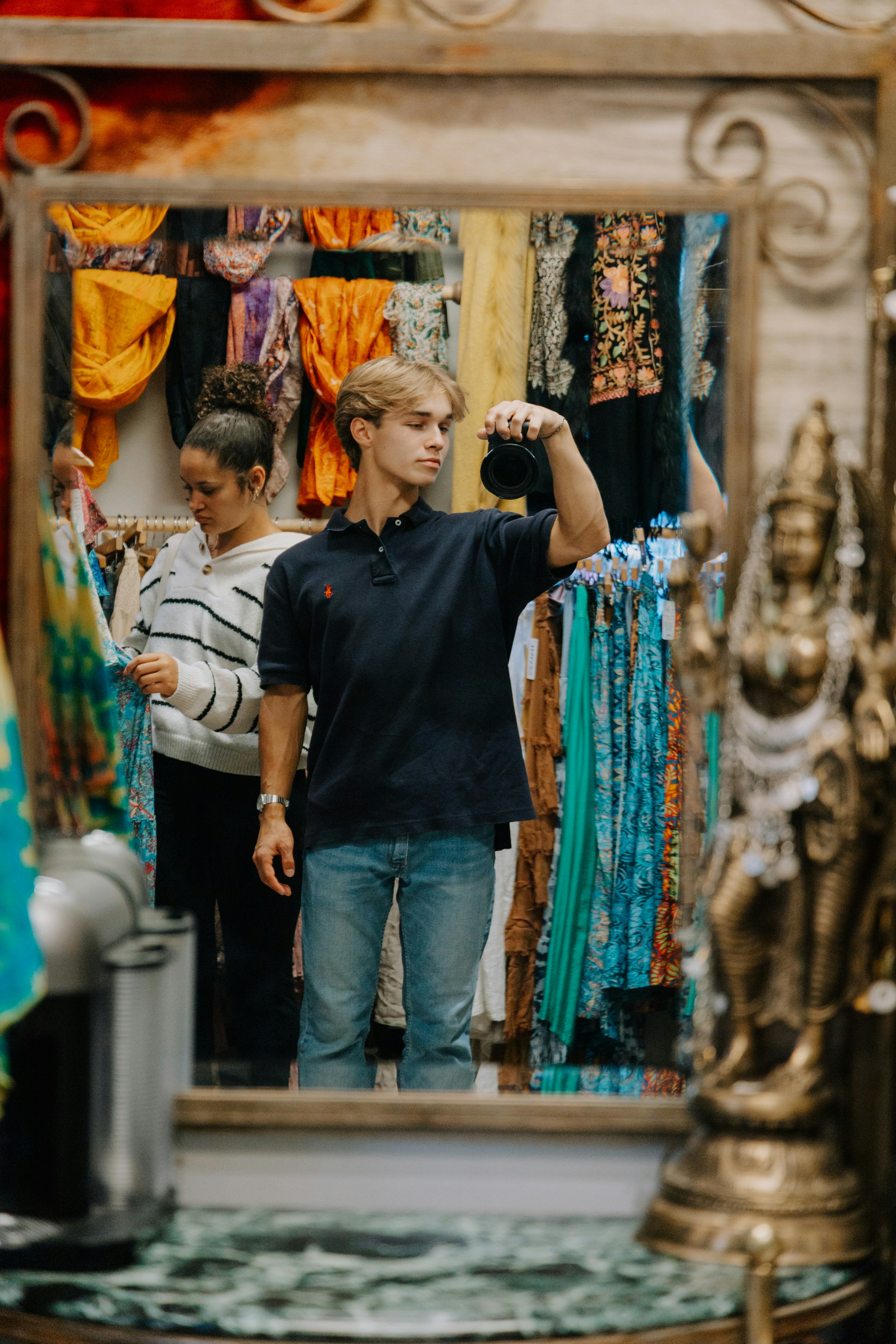 Young man takes a selfie in a clothing store.