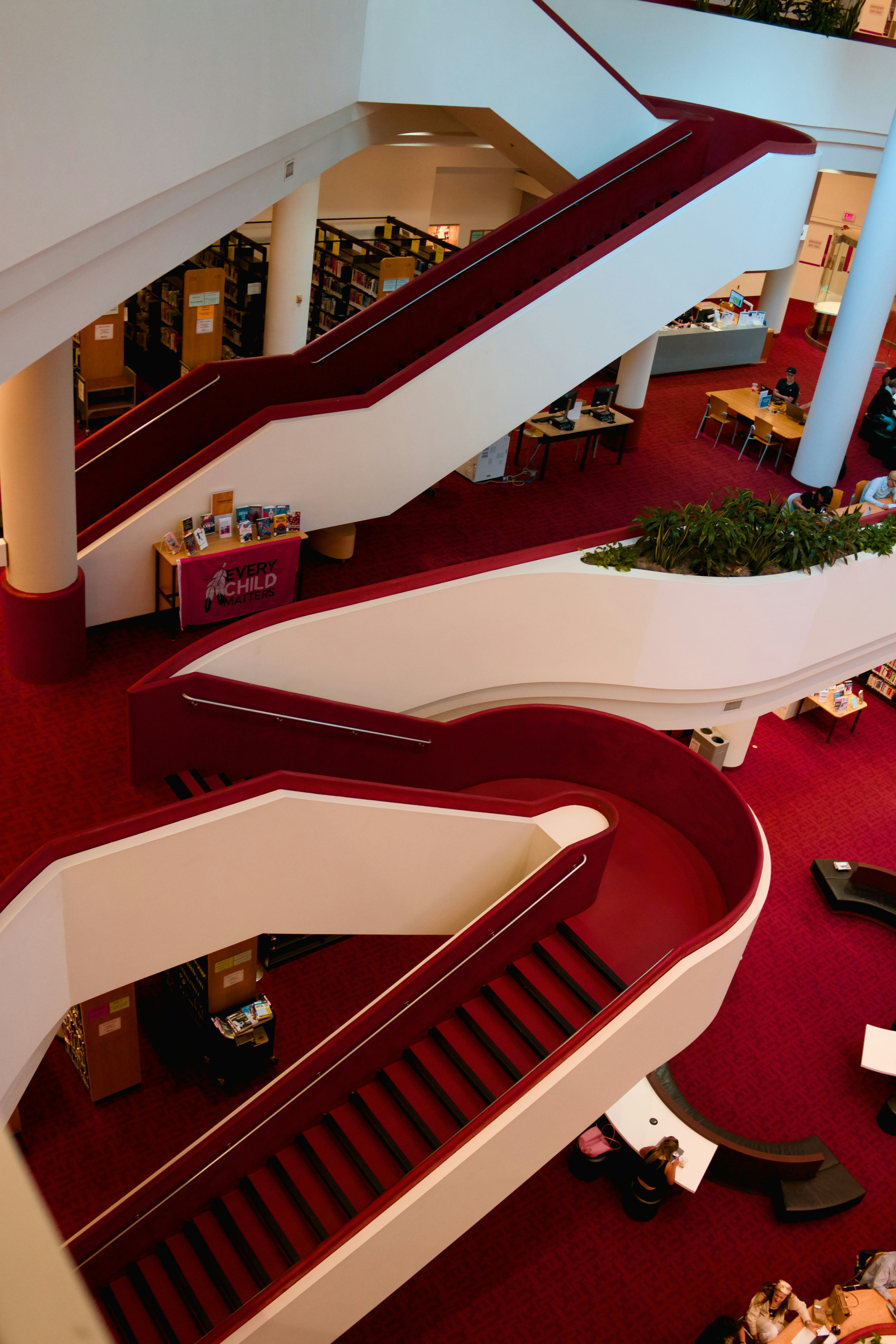 keep. | Modern library interior with red carpeted stairs