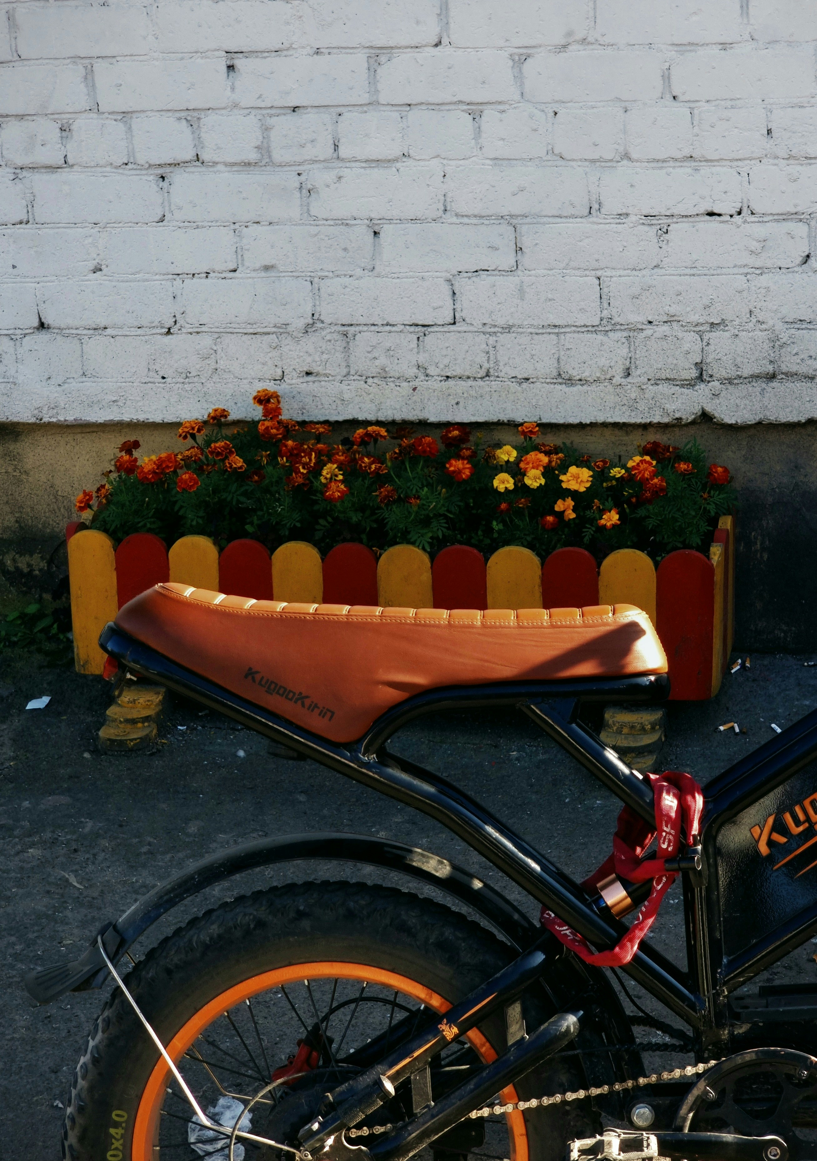 Brown leather bicycle seat against brick wall