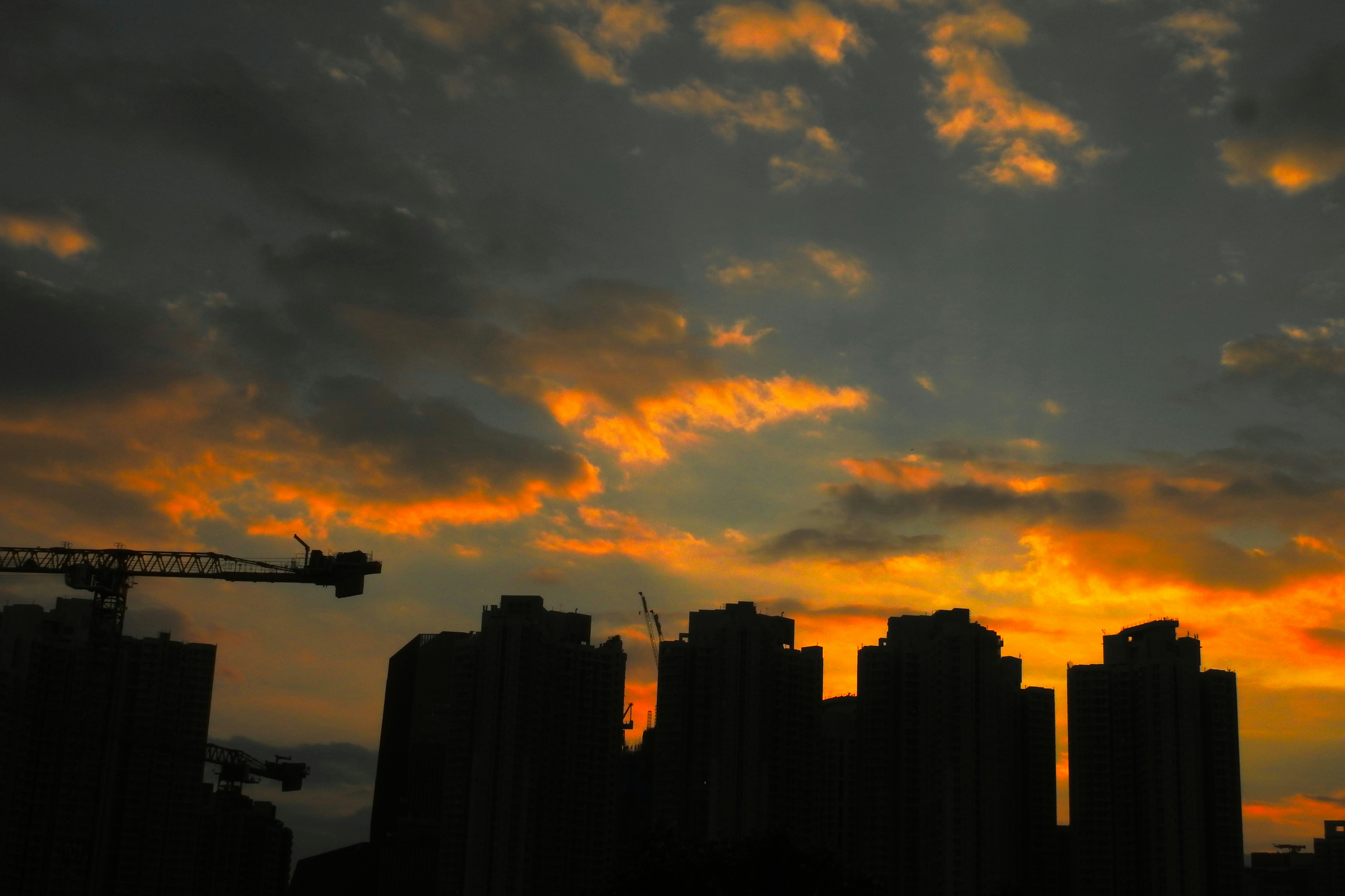 Silhouetted buildings against a dramatic sunset sky