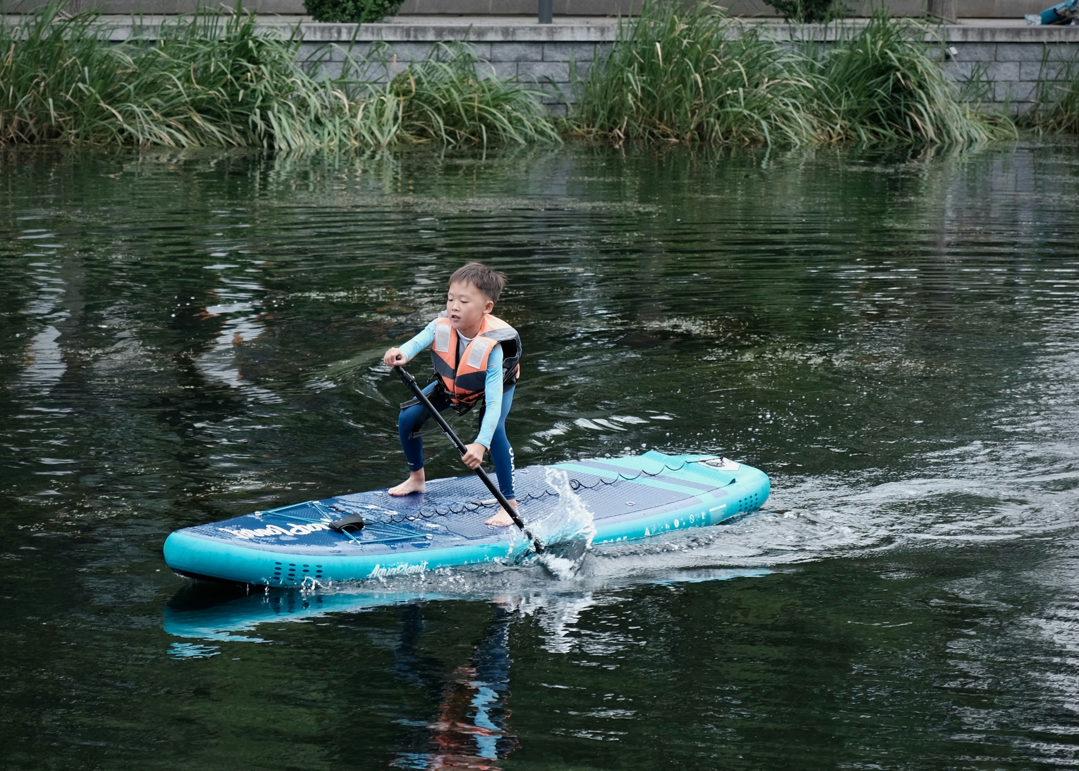 A person paddleboarding on a calm river