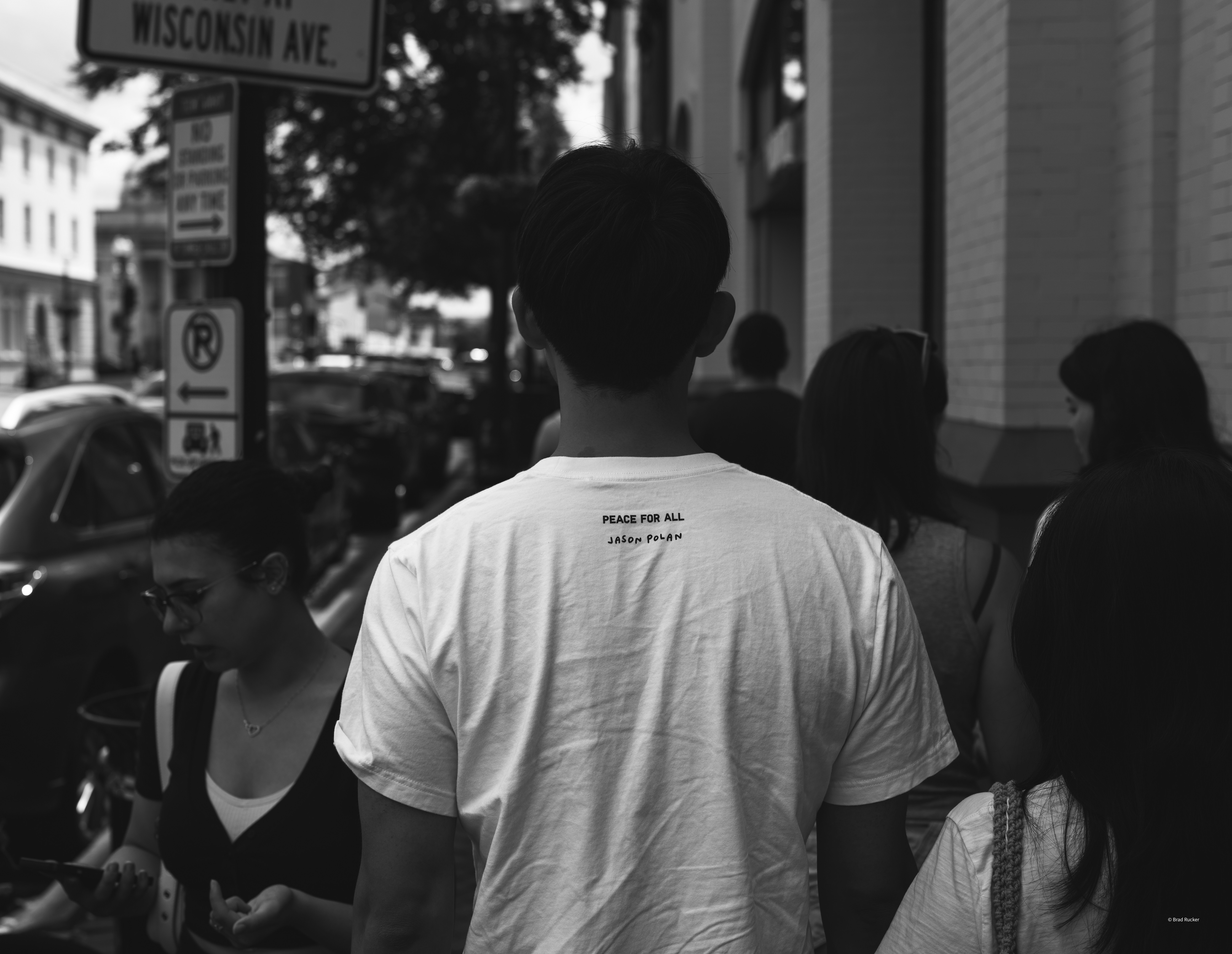 Man in white t-shirt walking on city street