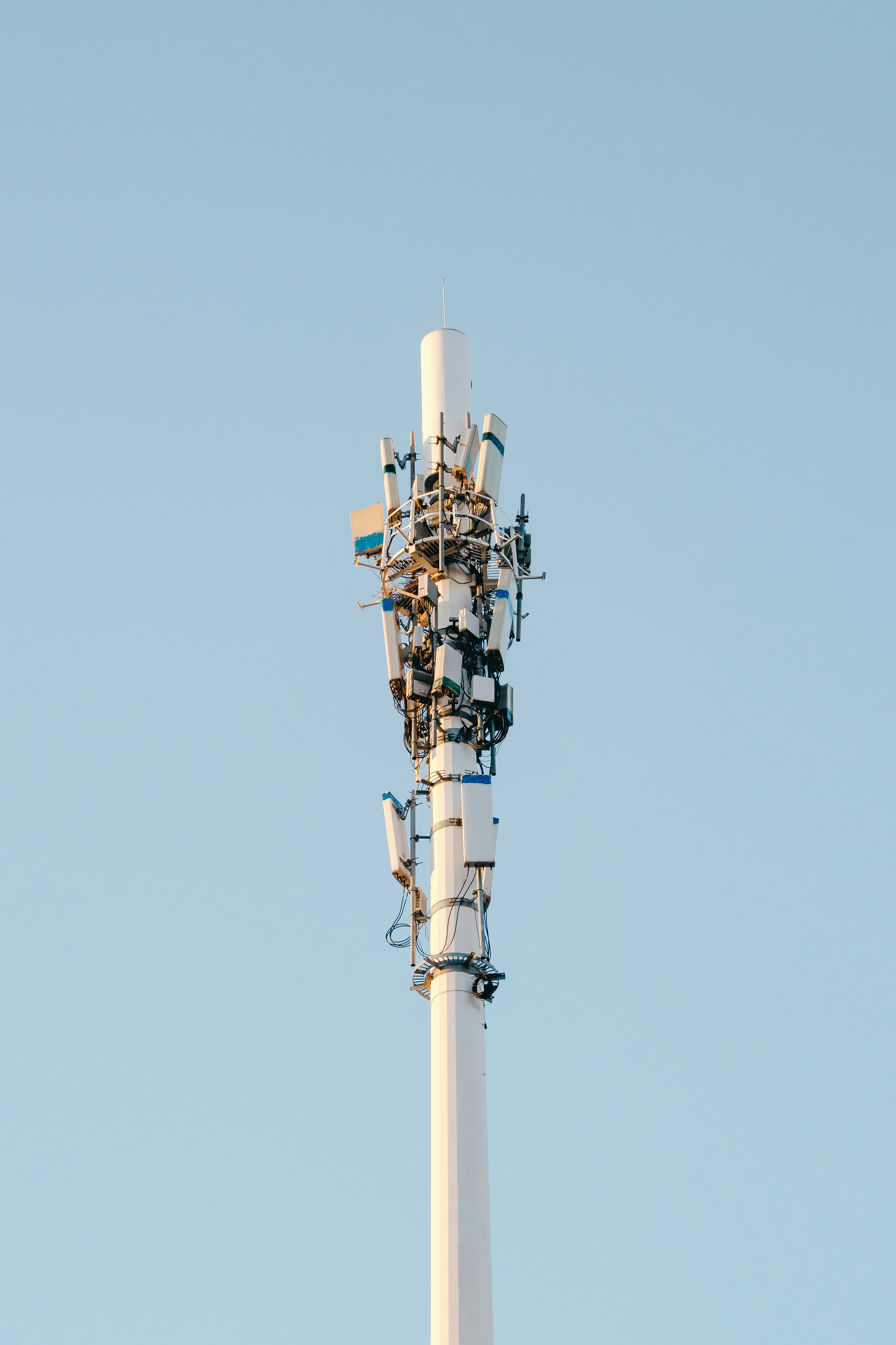 Lonely Signal Tower | Cell tower with antennas against a clear blue sky