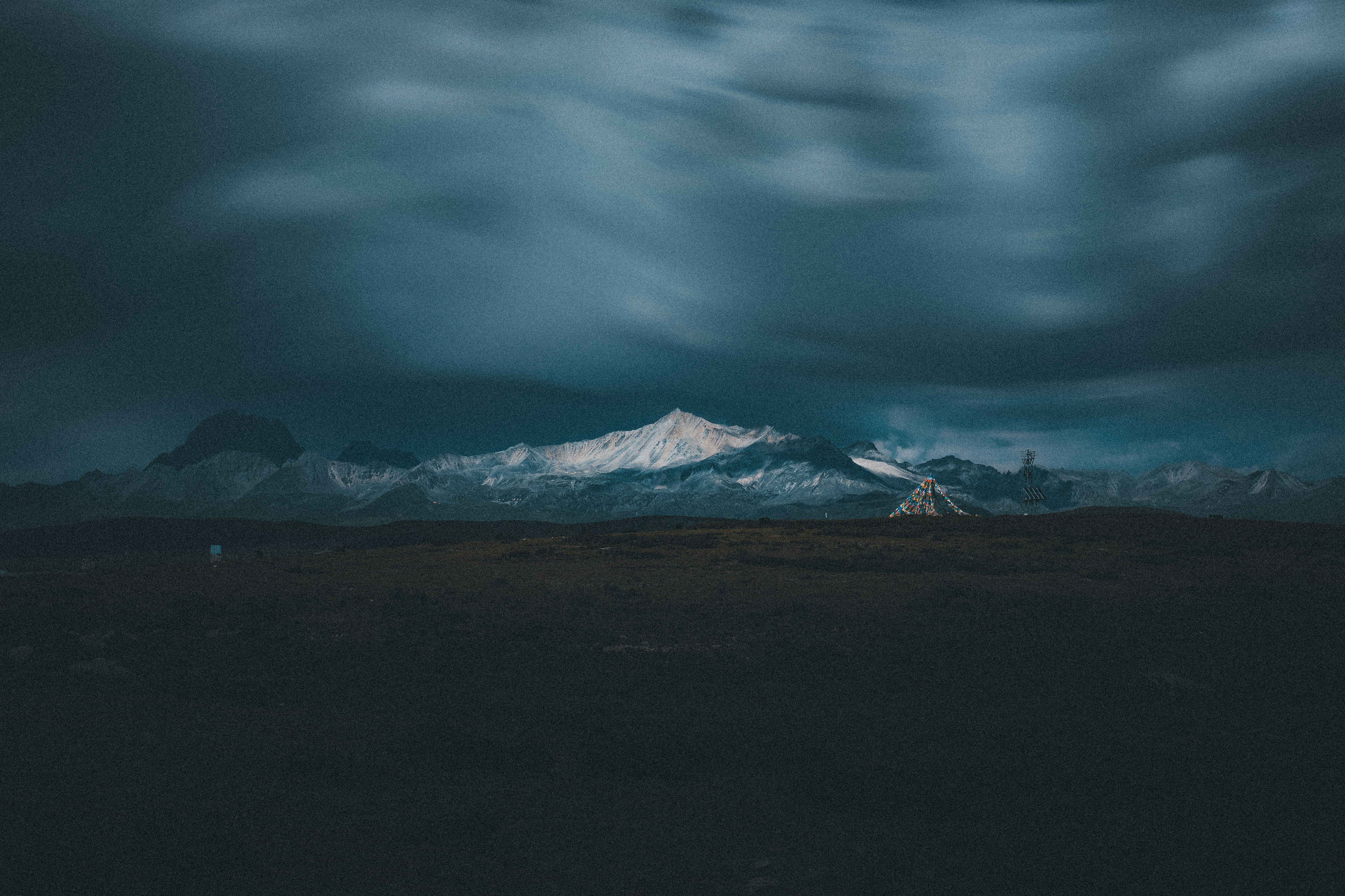 Snow-capped mountains under dramatic dark clouds