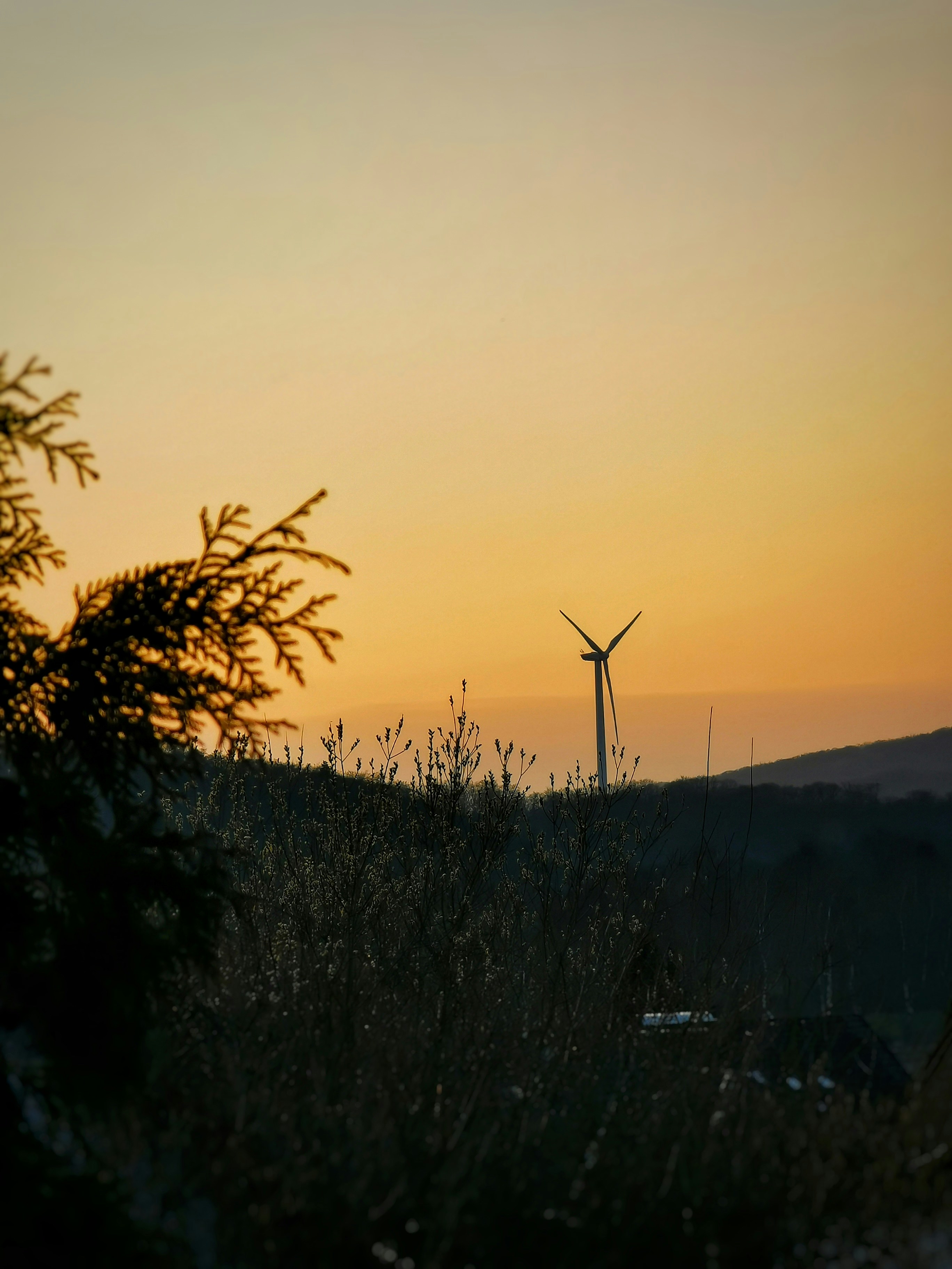 Wind turbine on a hill at sunset