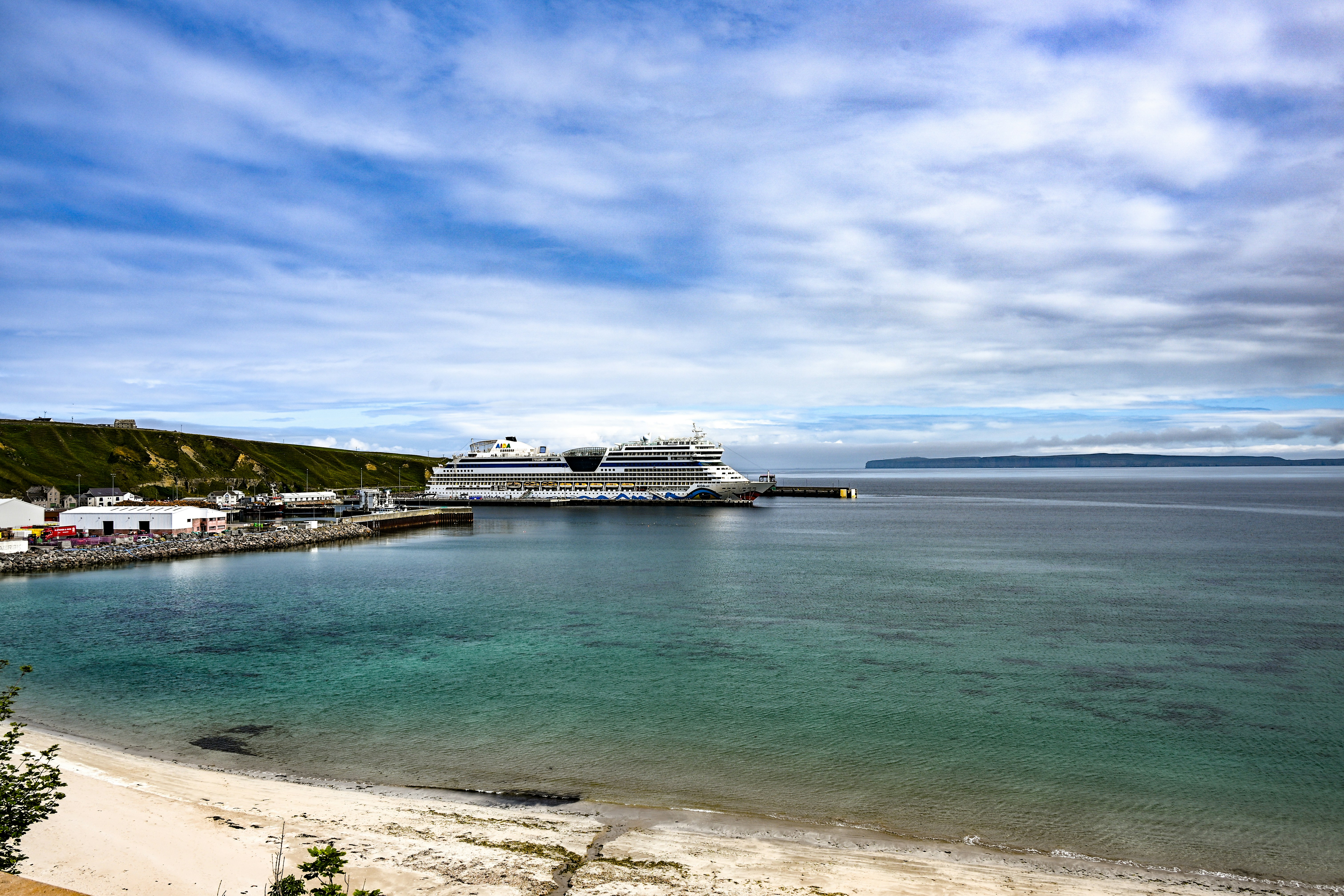 Azure Bay Harbor: Docked Cruise Ship Framed by Sky and Shore
