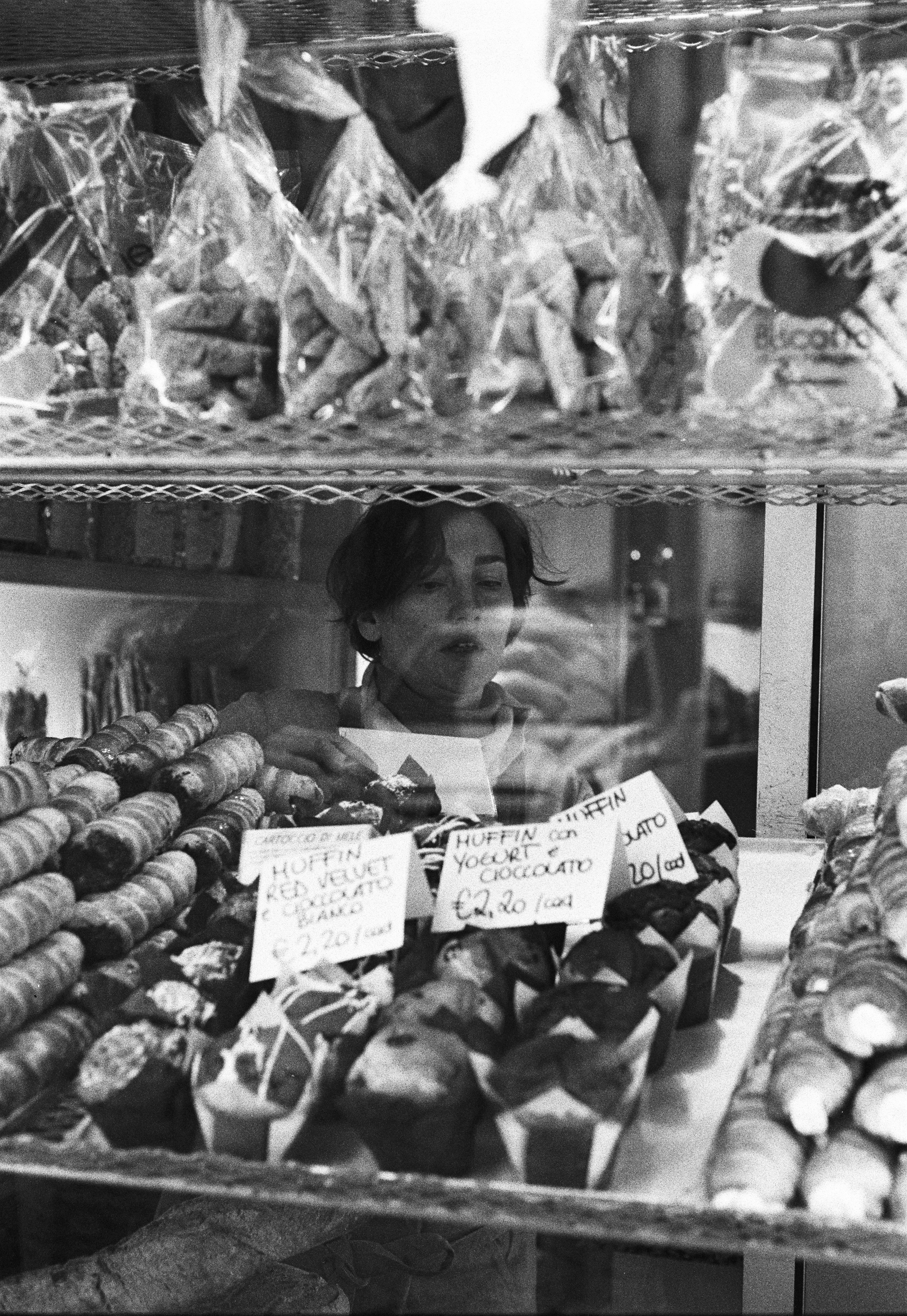 Baker arranging pastries | Baker arranging pastries in a display case