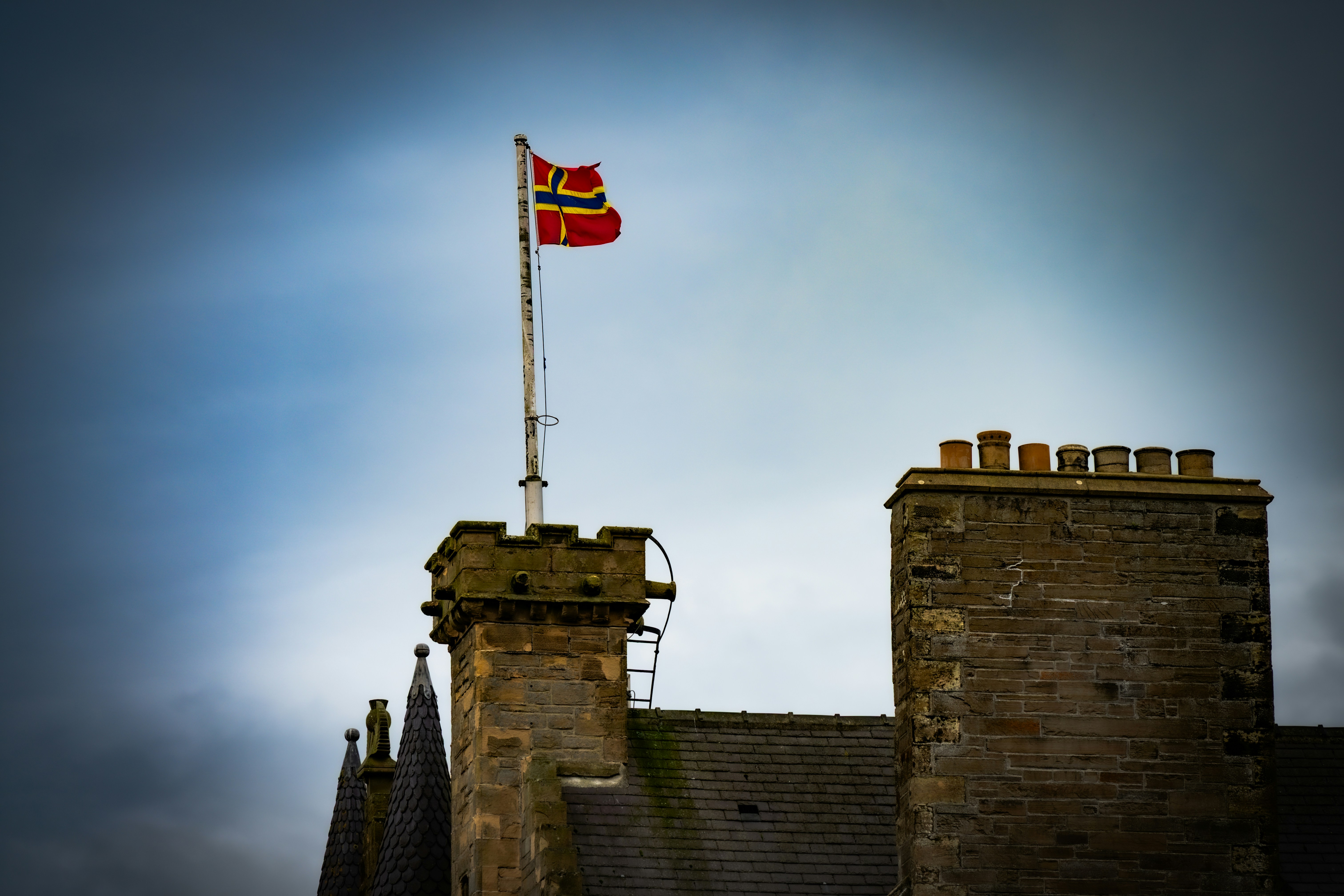 Red flag flies atop a stone building photo – Free City Image on Unsplash