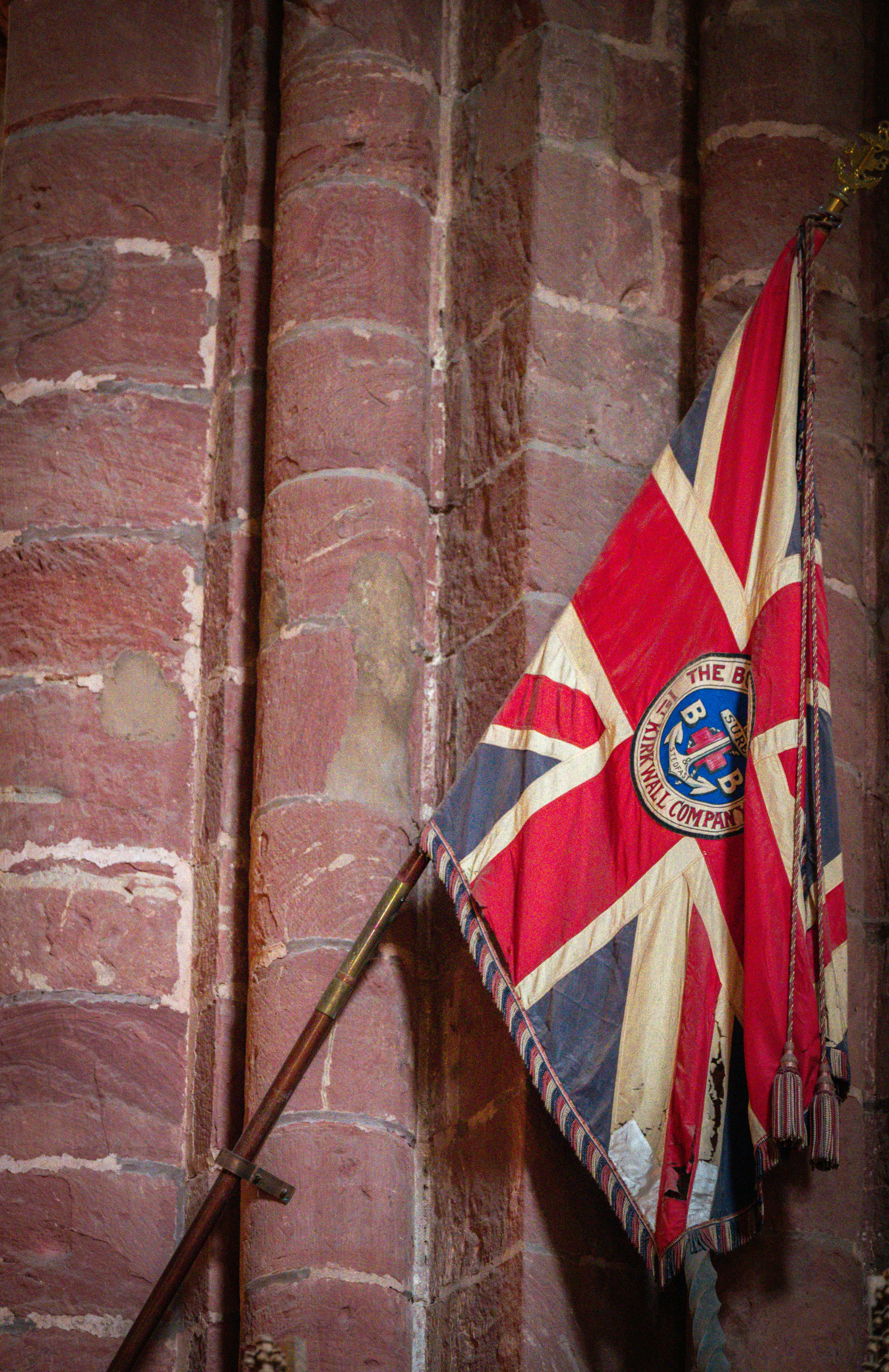 Union Jack Draped by Crimson Columns in a Dim Interior