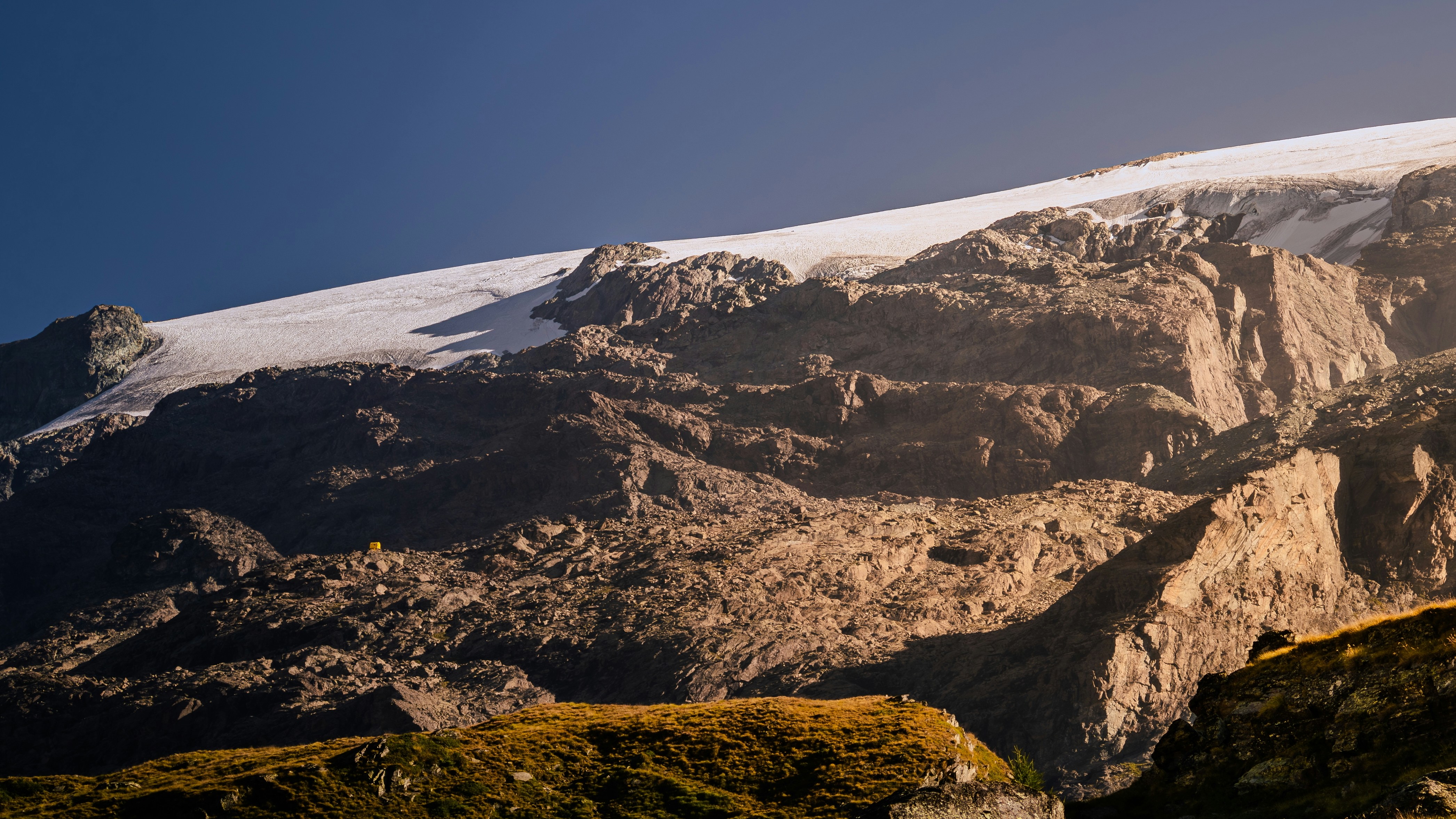 Sunrise over Italian Alps | Rocky mountain slope with snow and blue sky