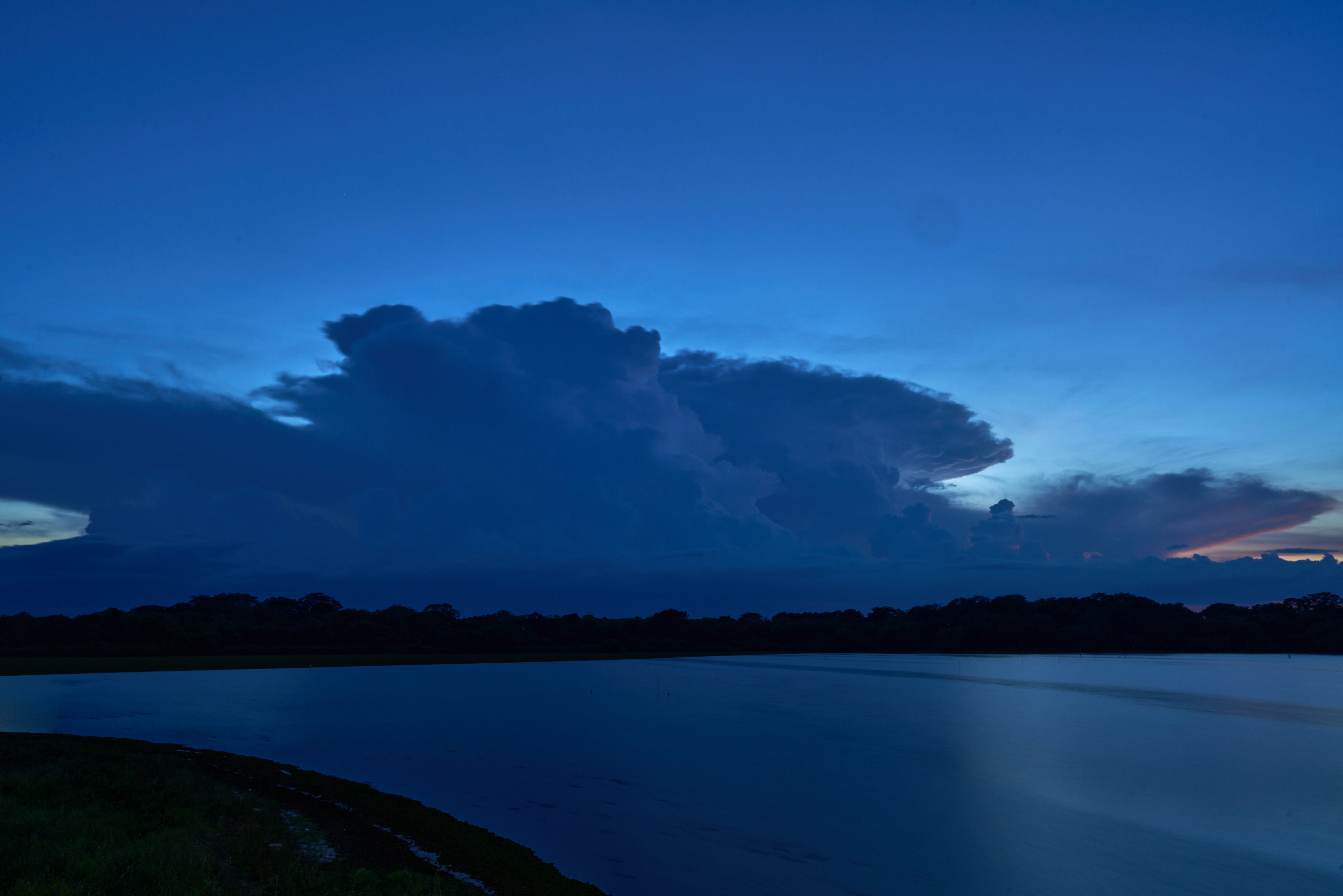 Dramatic clouds over a calm lake at dusk