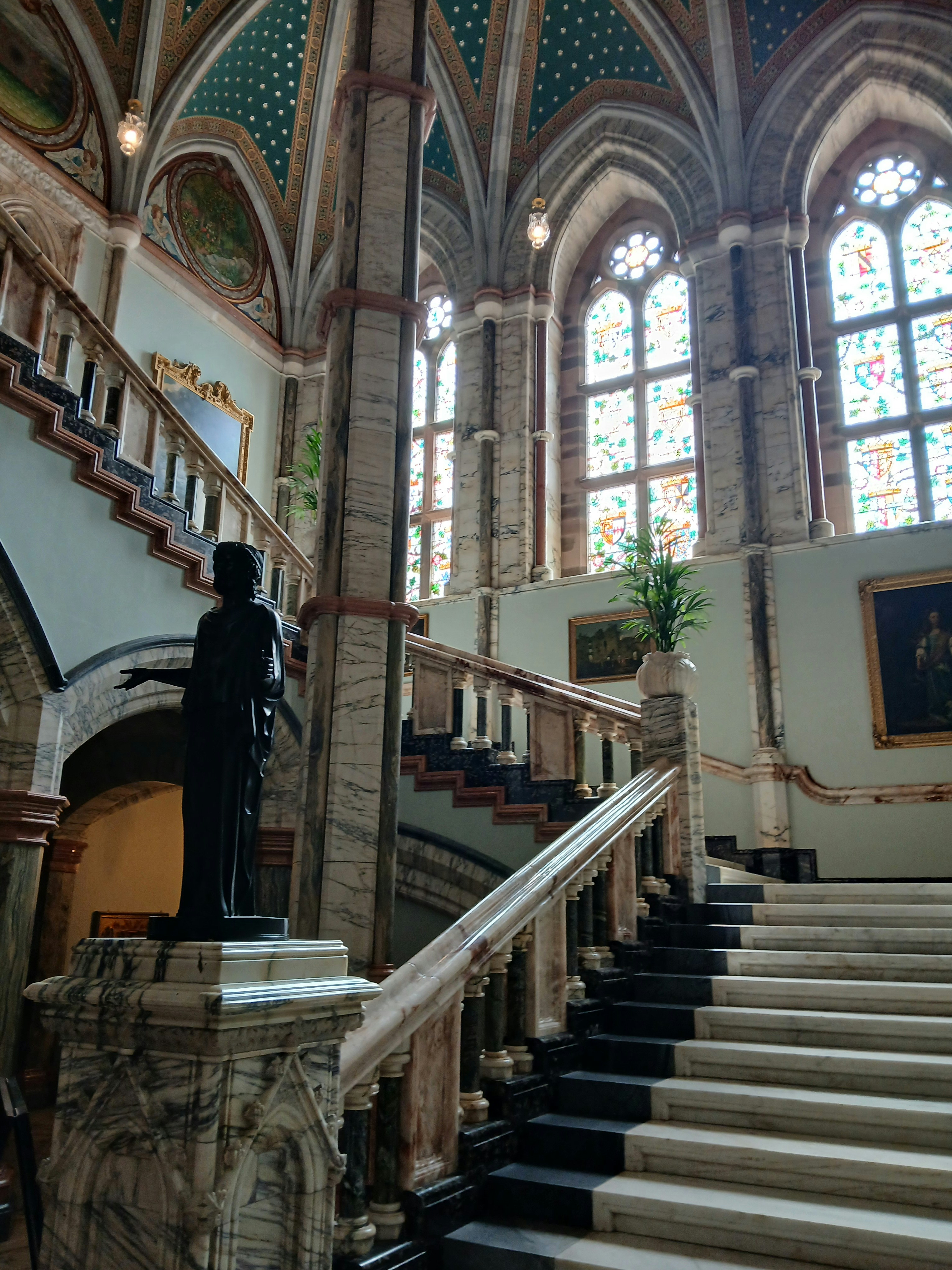 The main staircase at Mount Stuart, Isle of Bute, Scotland. | Grand staircase with stained glass windows in ornate building