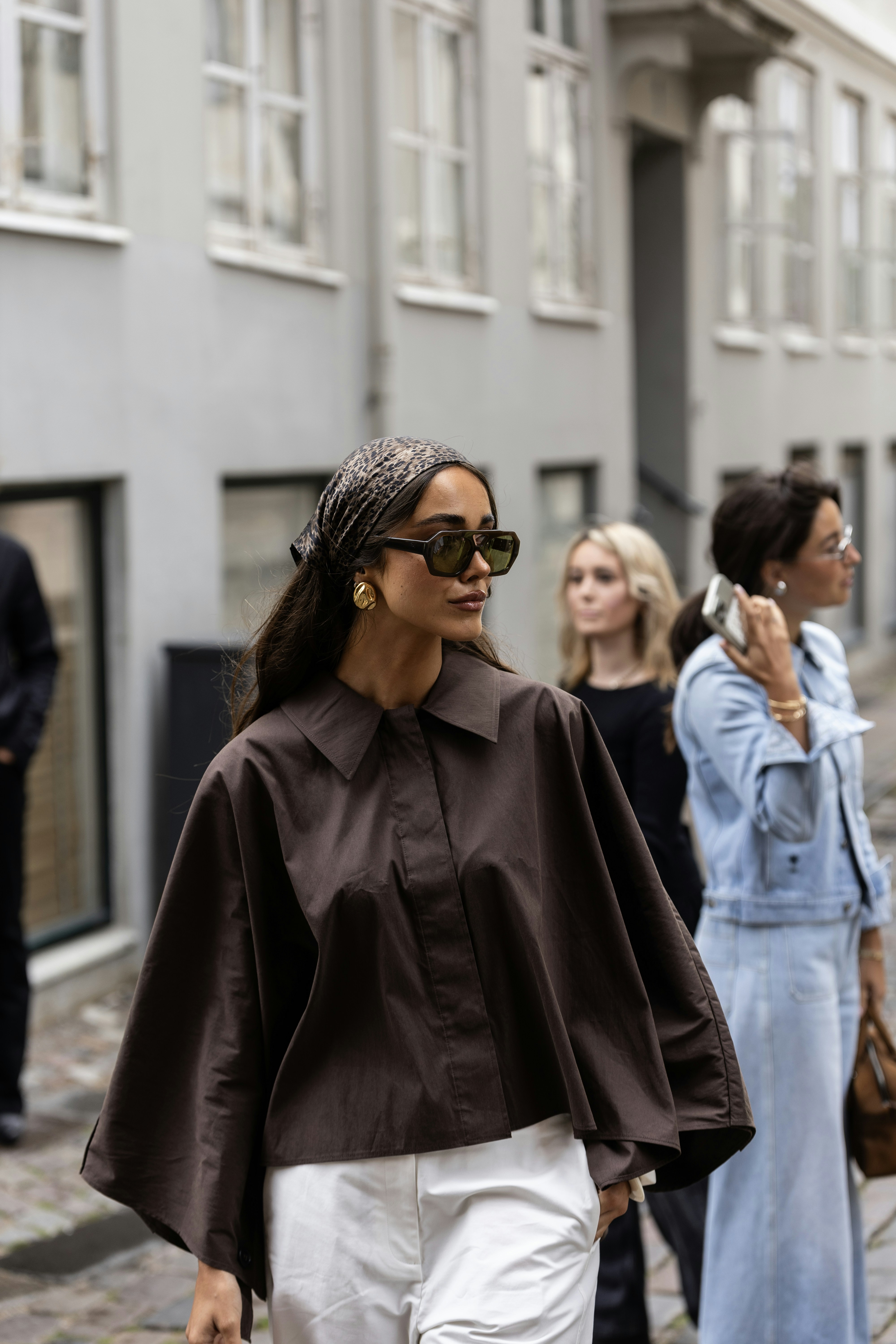 Bold Street Style: A Woman in Cocoa Draped Cape Walks Past City Neighbors