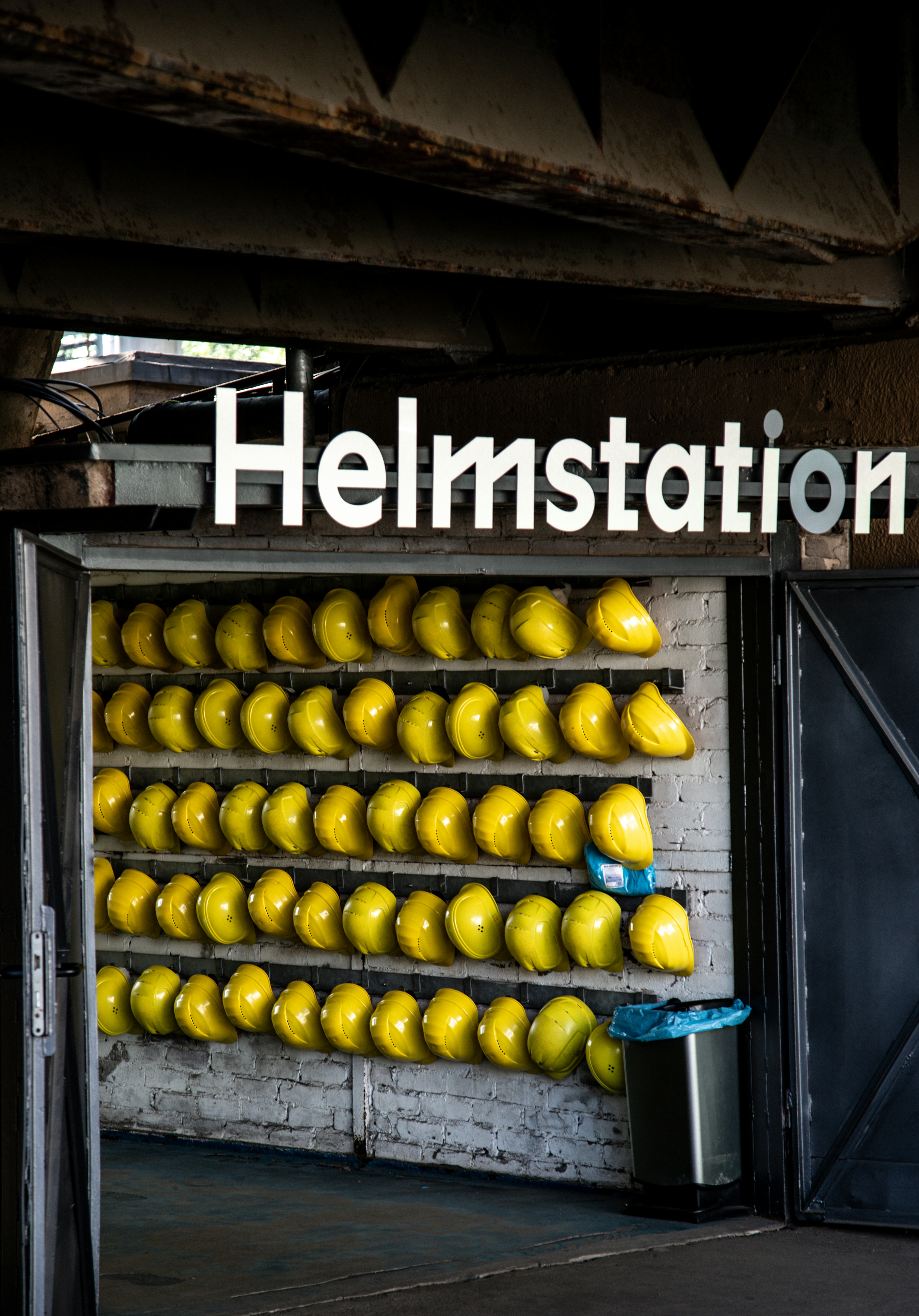 Yellow Safety Helmets Align Under the Helmstation Sign