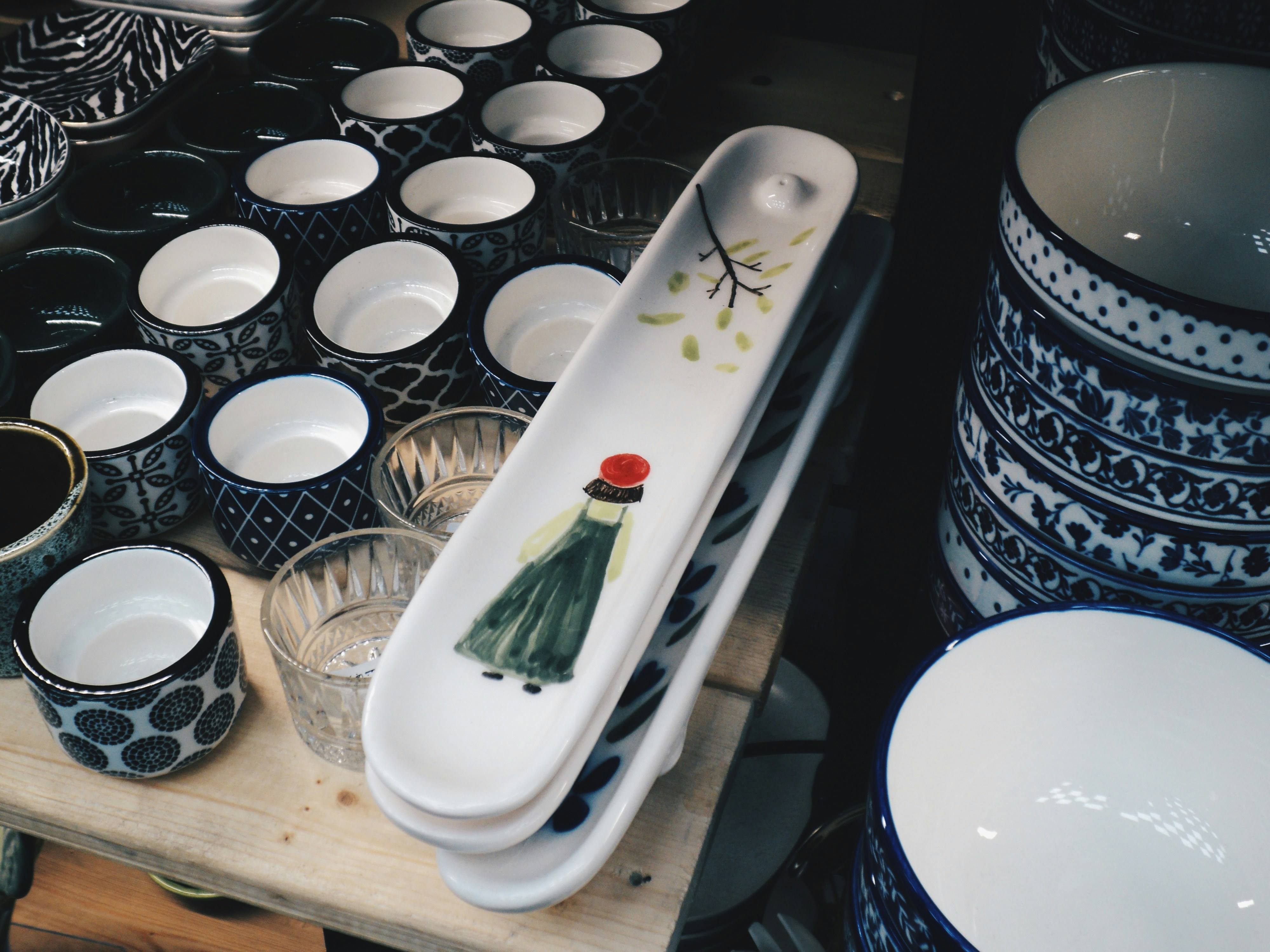 The quiet beauty of a handcrafted piece. | White ceramic dishes with decorative painted figures.
