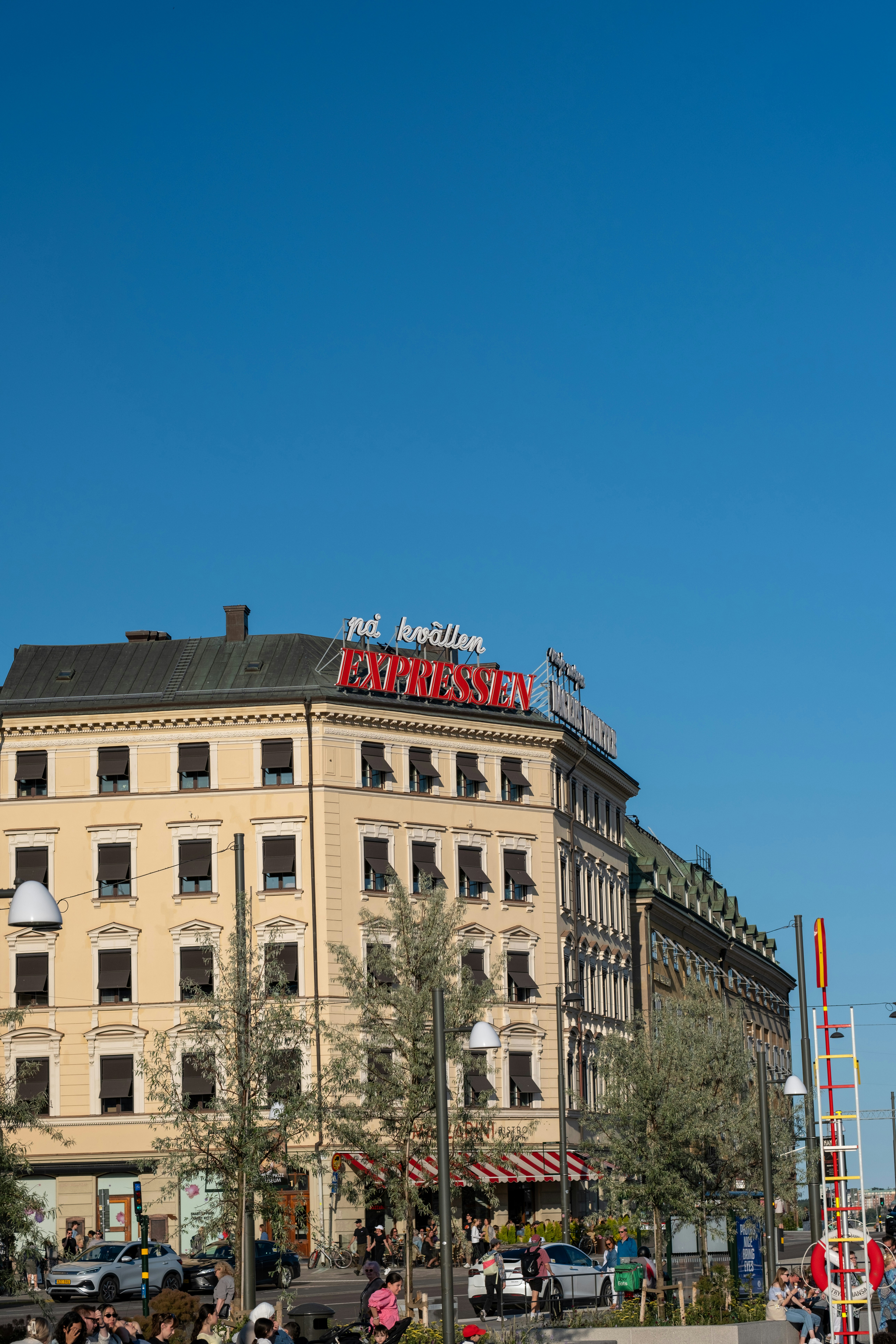 Historic building adorned with a vibrant sign, capturing the essence of urban culture. The scene is lively with pedestrians enjoying the day.