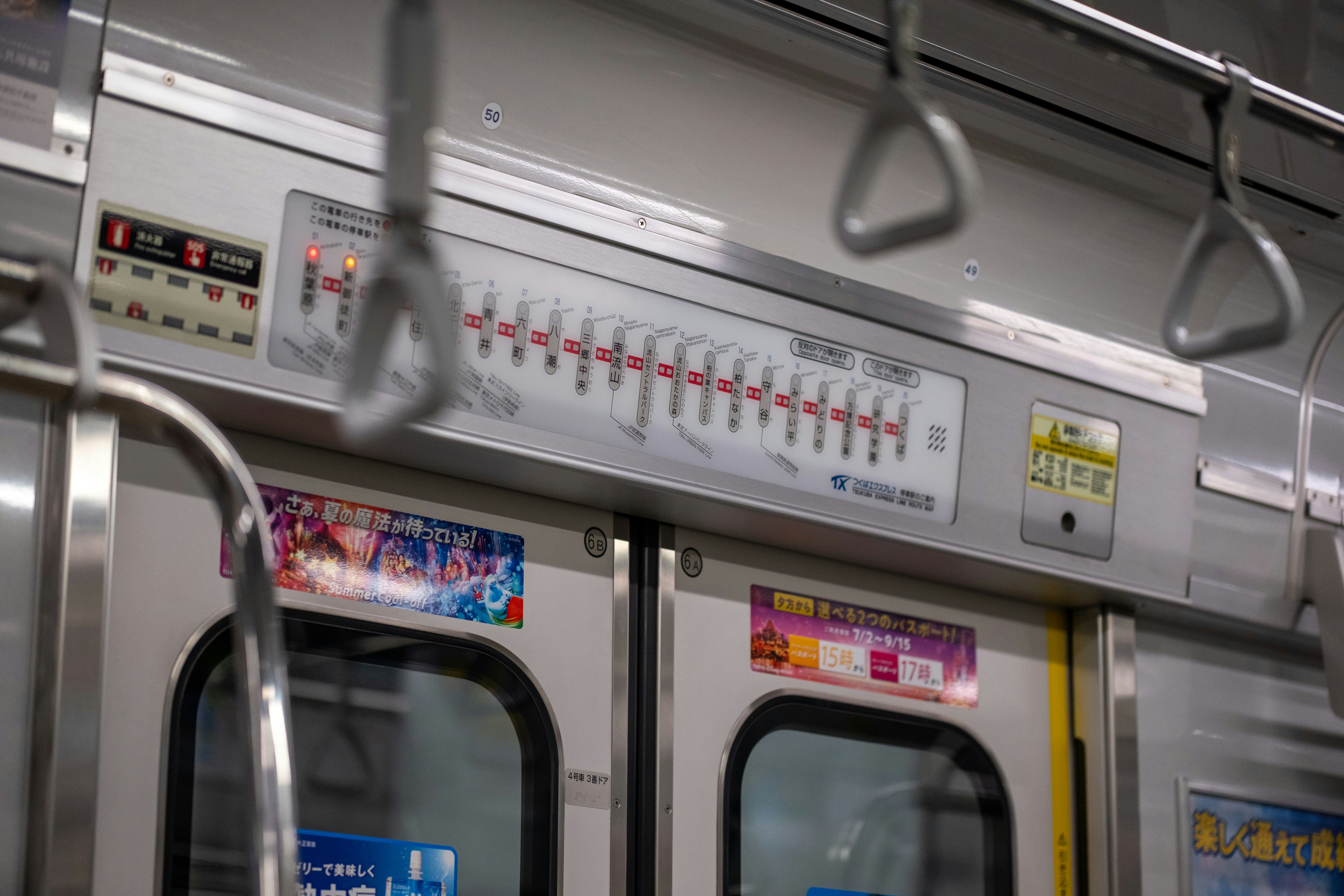 Interior of a train with handles and route map