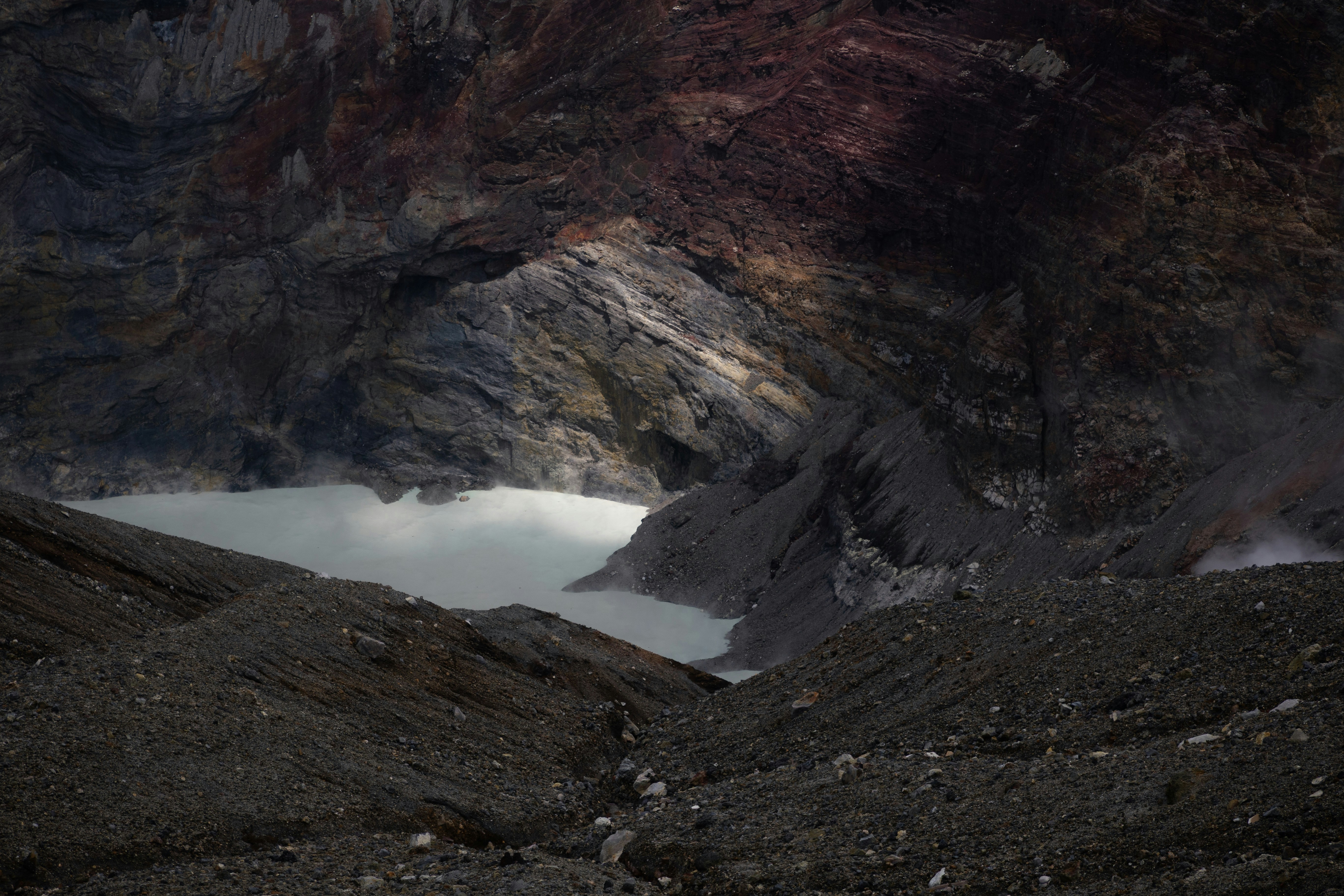 Crater lake surrounded by rocky volcanic terrain