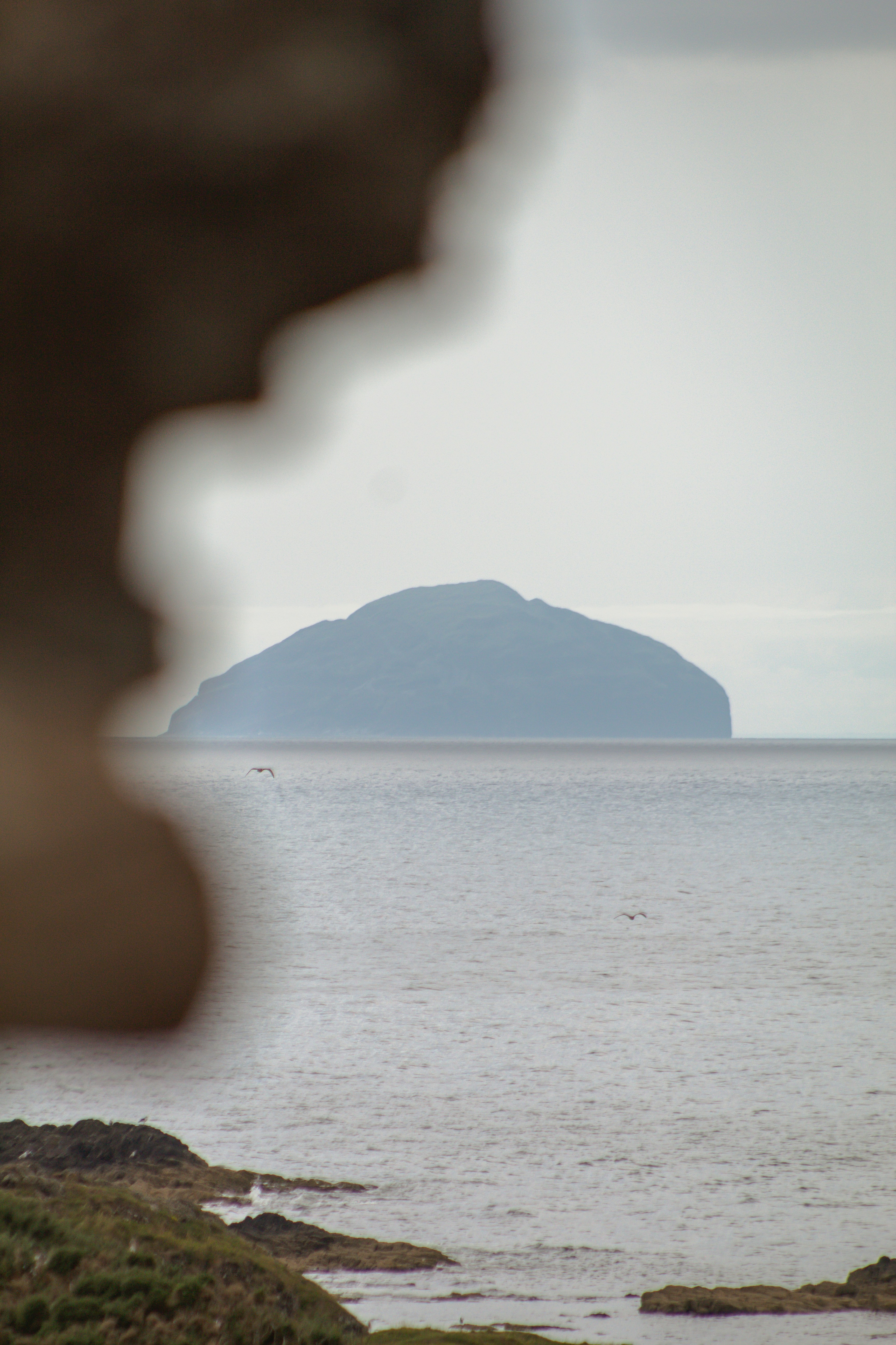 Island on the ocean seen through a stone archway