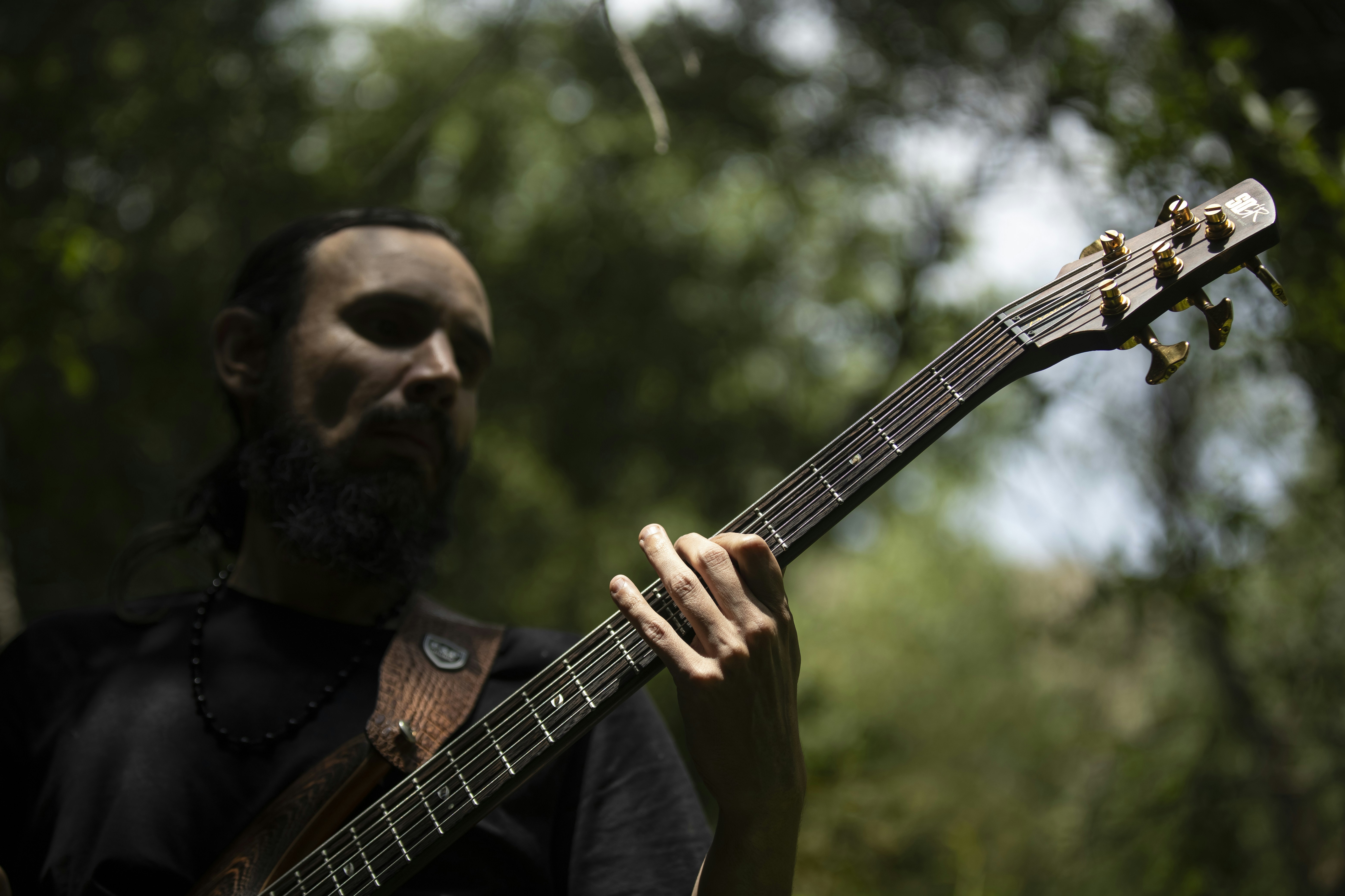 Man playing a bass guitar outdoors