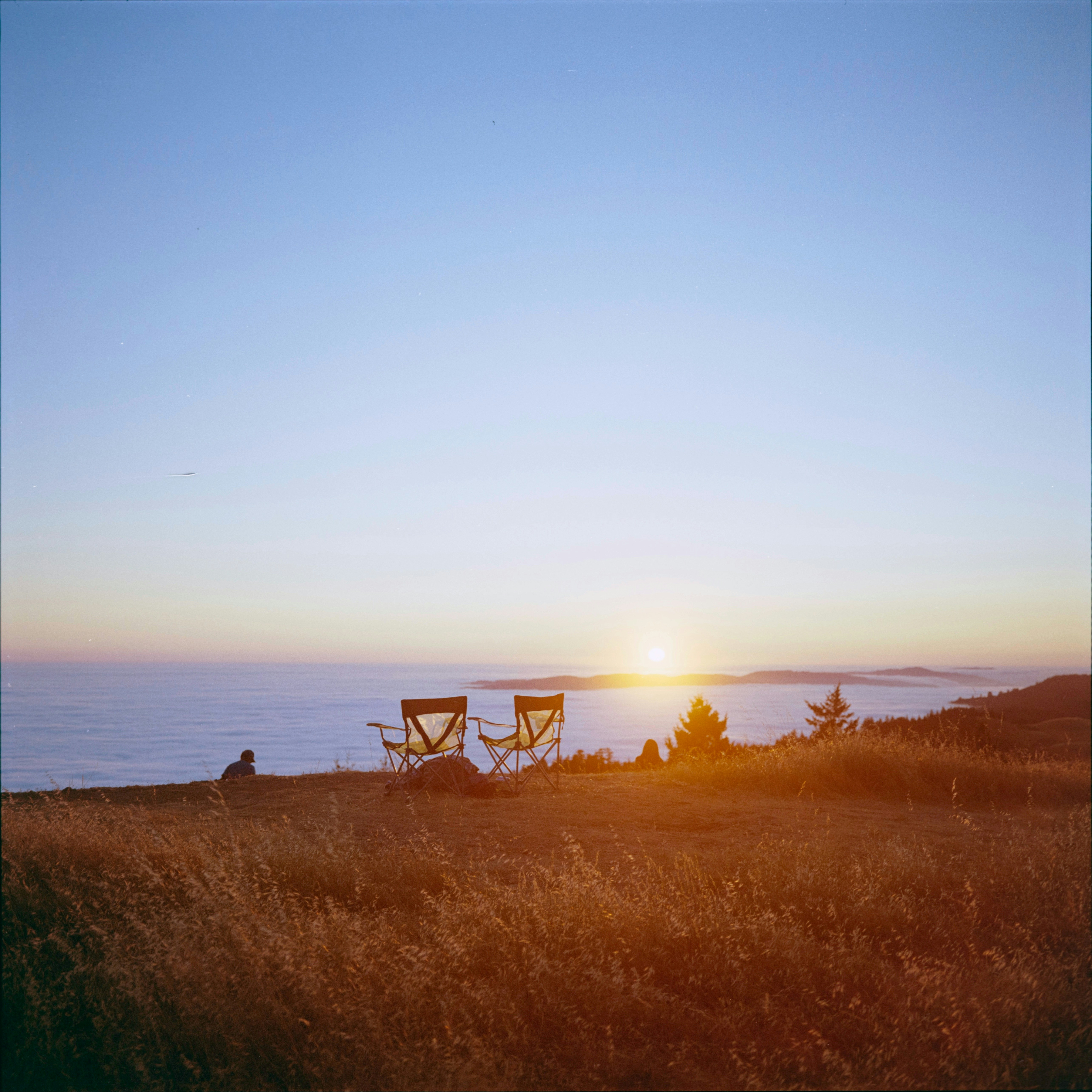 Two Folding Chairs at Sunset on a Quiet Coastal Ridge