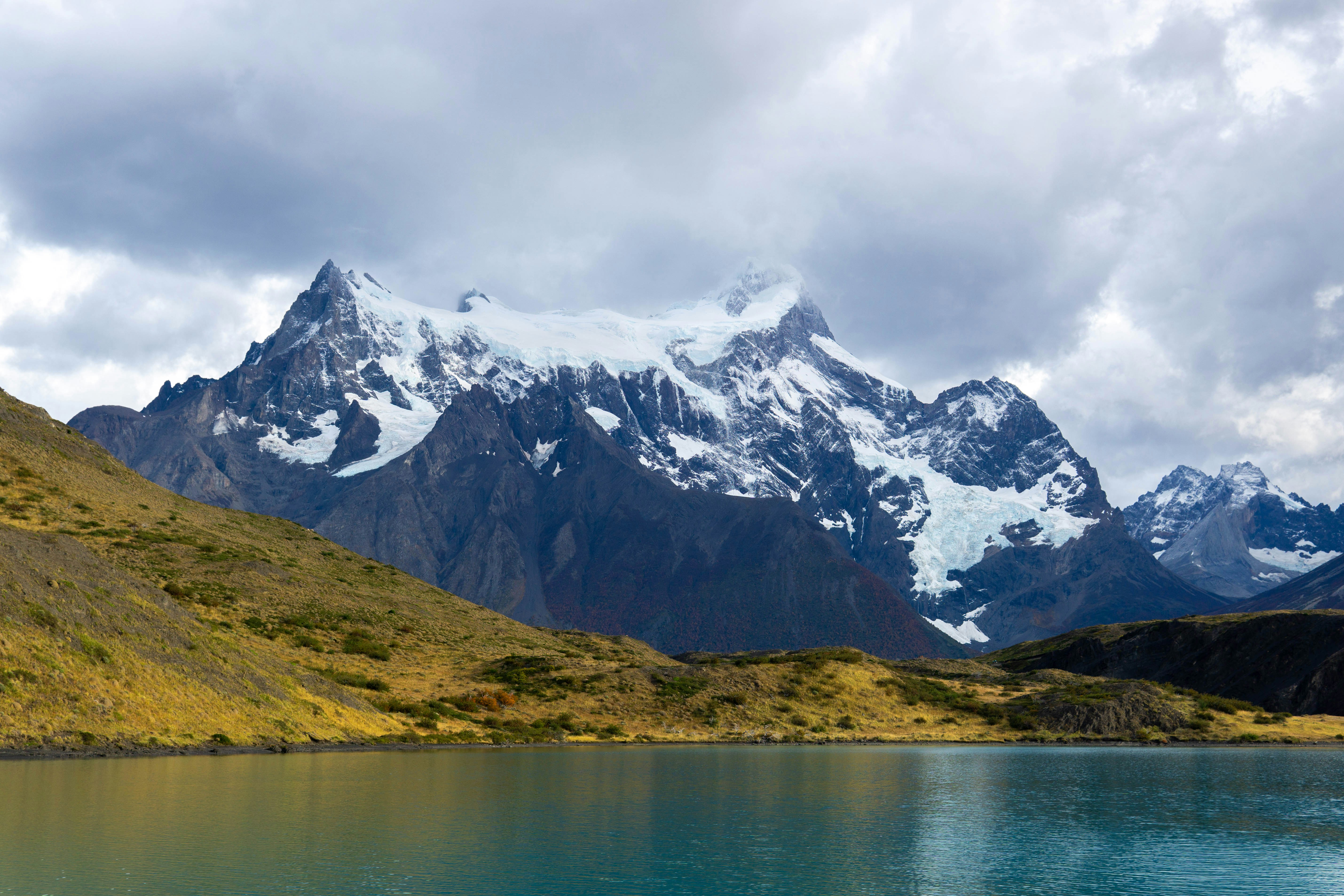 Torres del paine hike | Snow-capped mountains rise above a calm lake