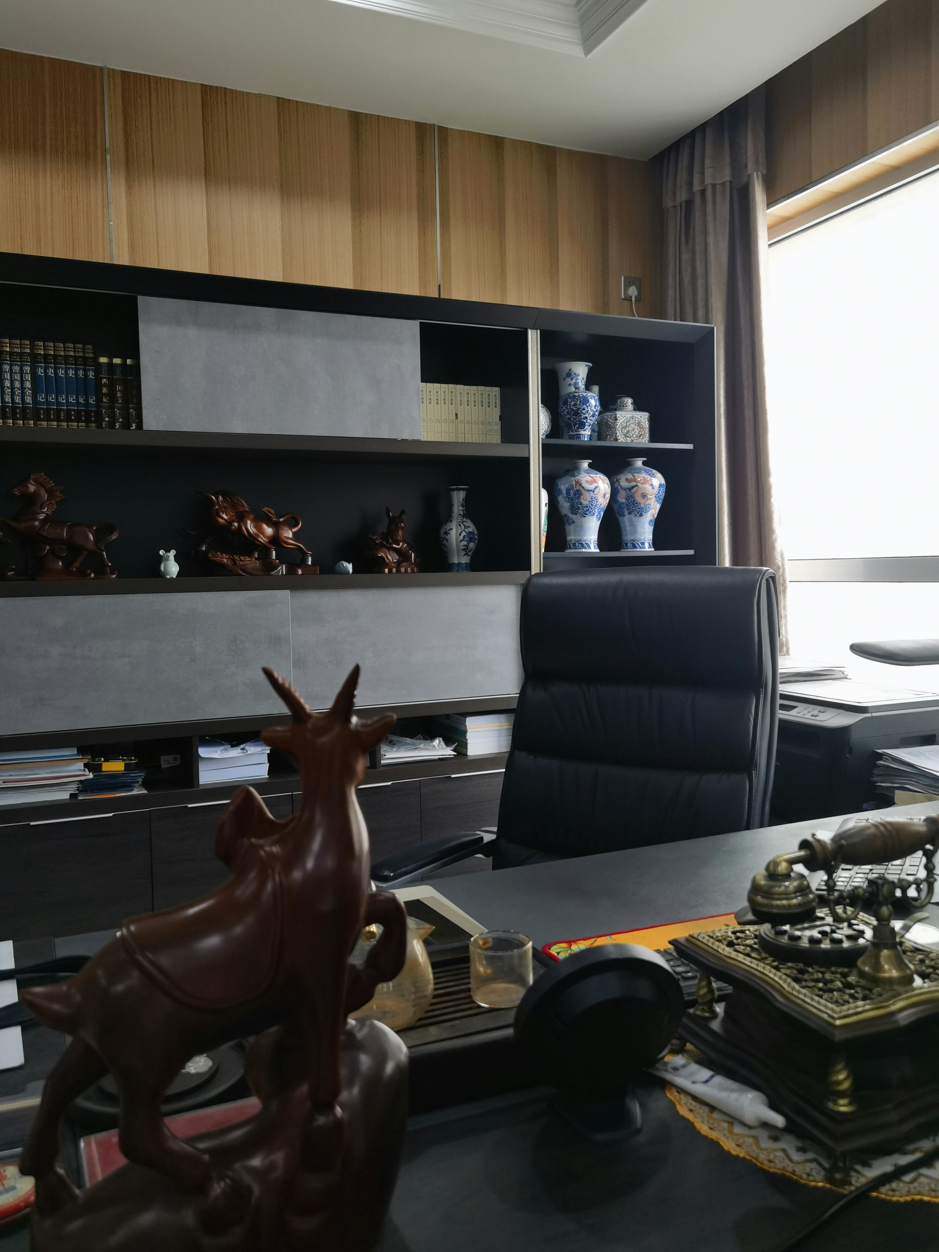 Executive office with desk, chair, and shelves.