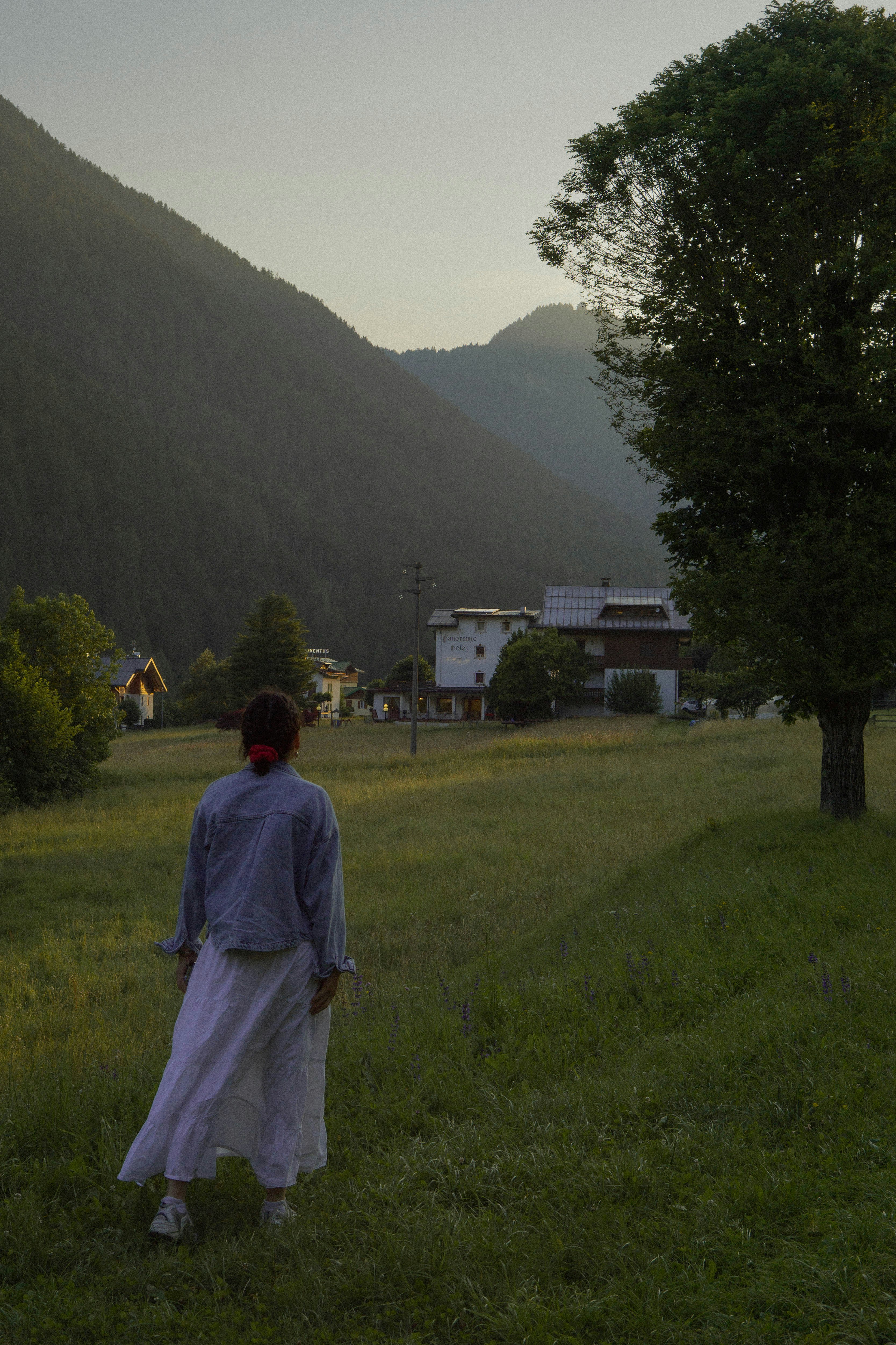 Woman enjoying sunset | Woman looking at a valley with mountains at sunset