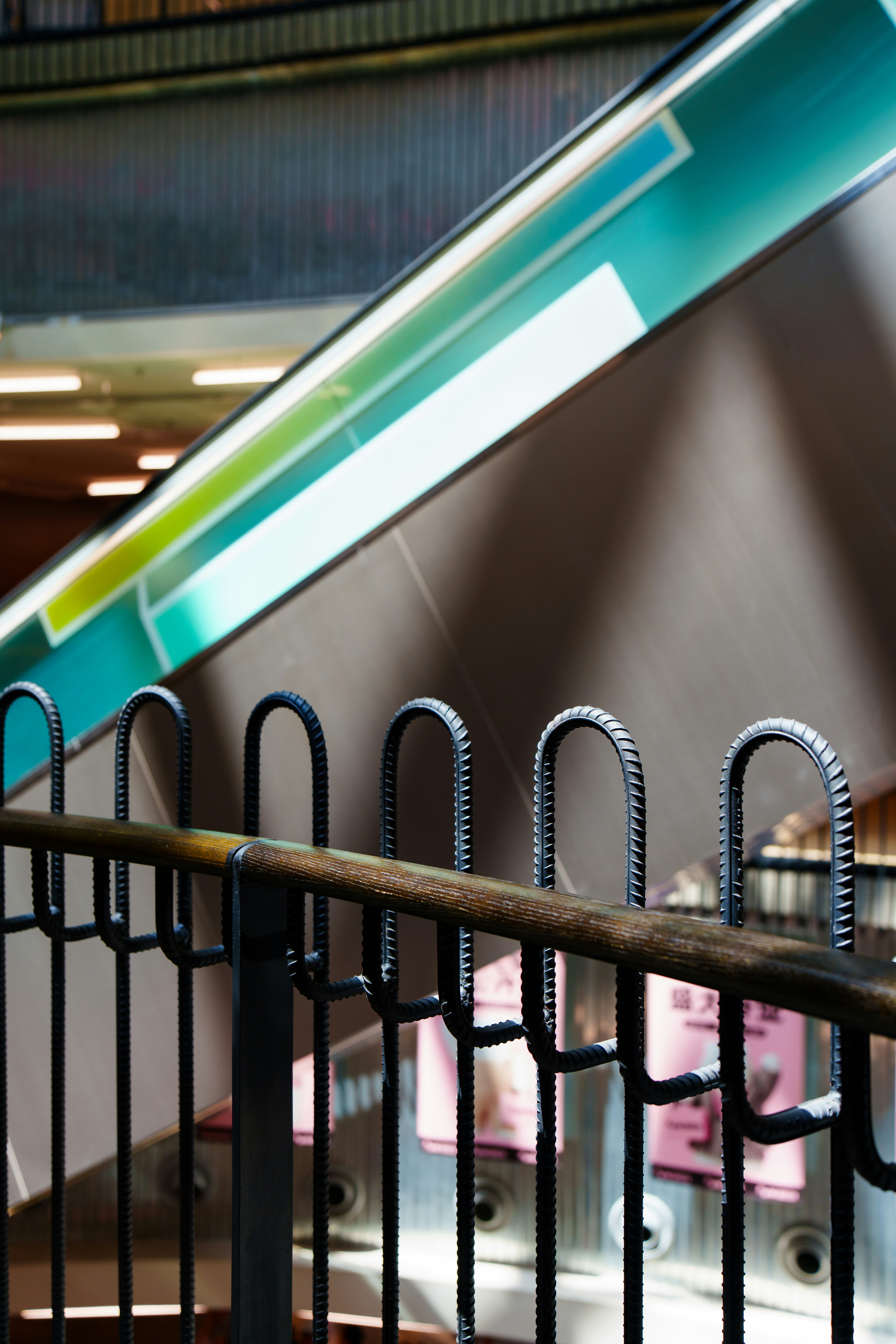 Escalator with metal railing and posters