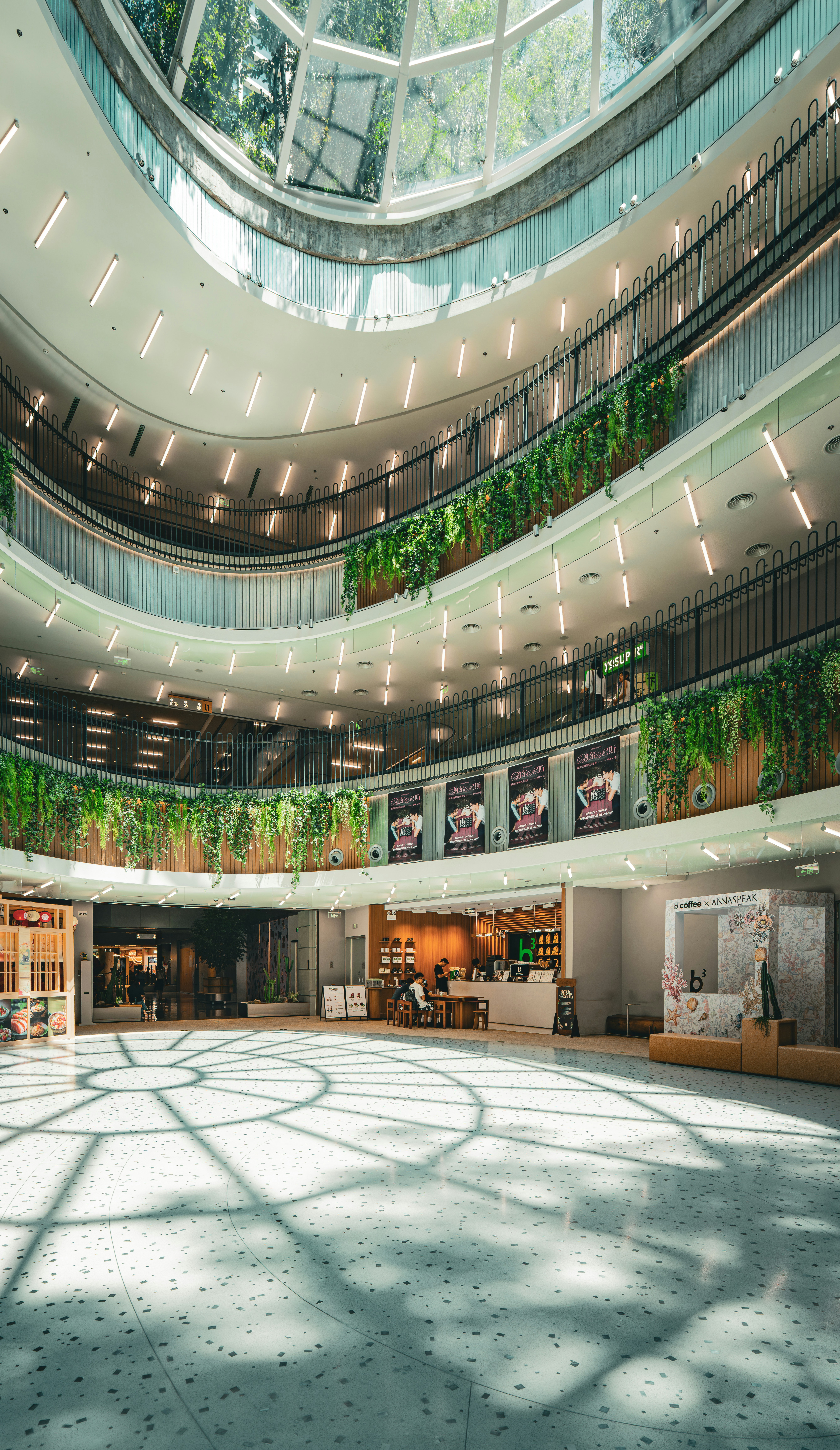 Modern atrium with plants and natural light patterns.