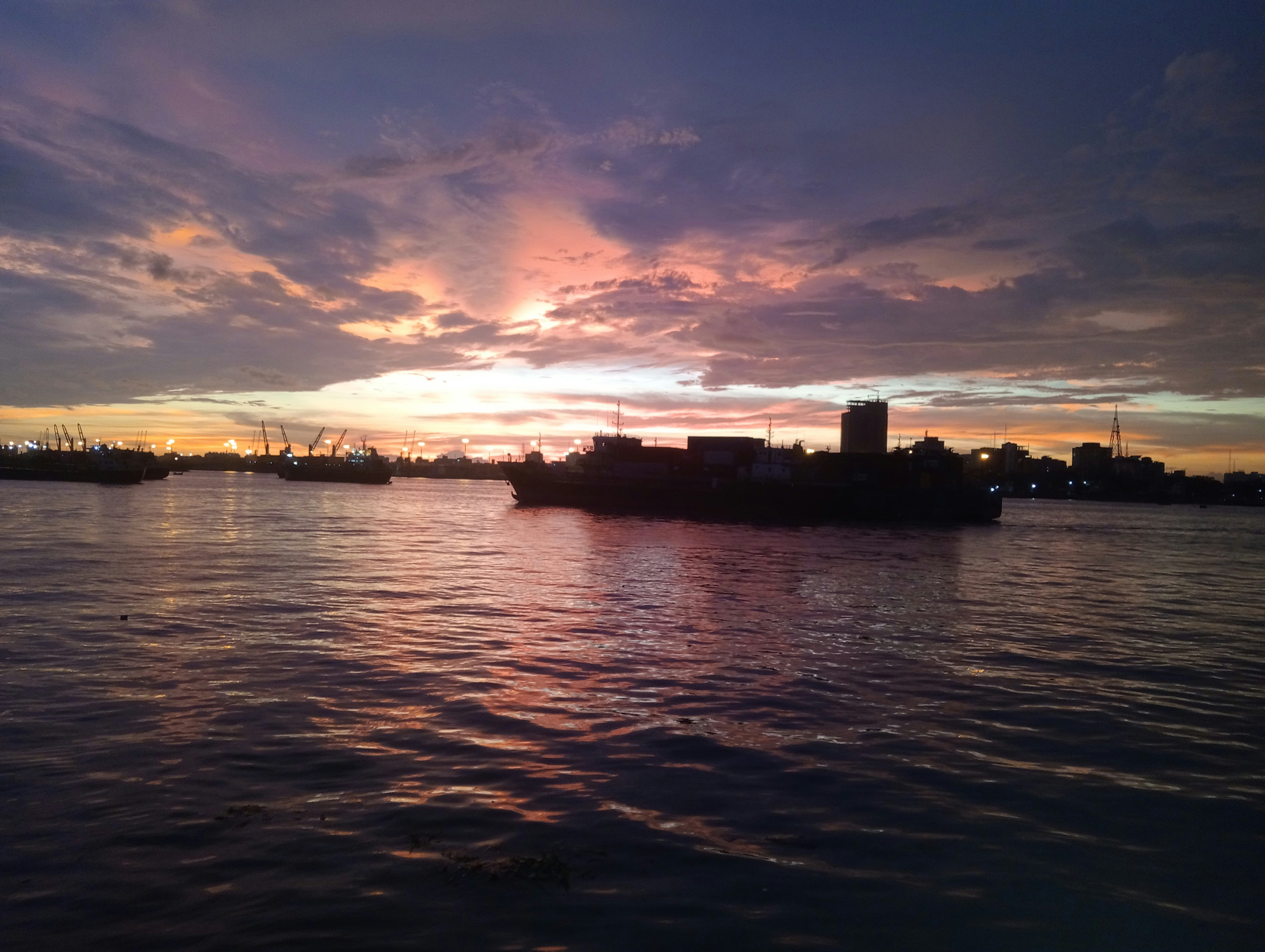 Sunset over Karnaphuli River, Chittagong Port. | Ships on the water during a colorful sunset