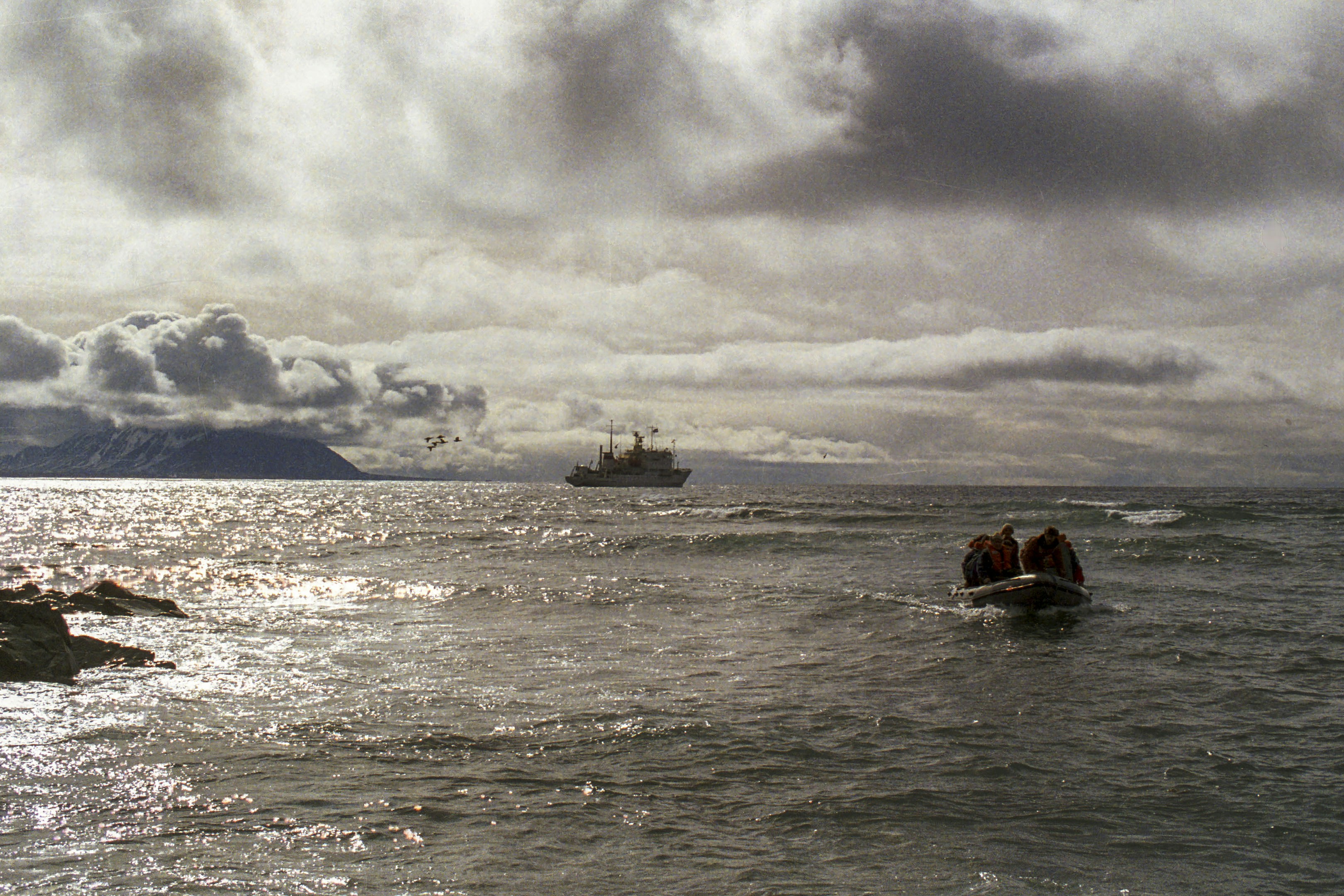 A ship sails on the ocean near a rocky shore. photo – Free Human Image ...