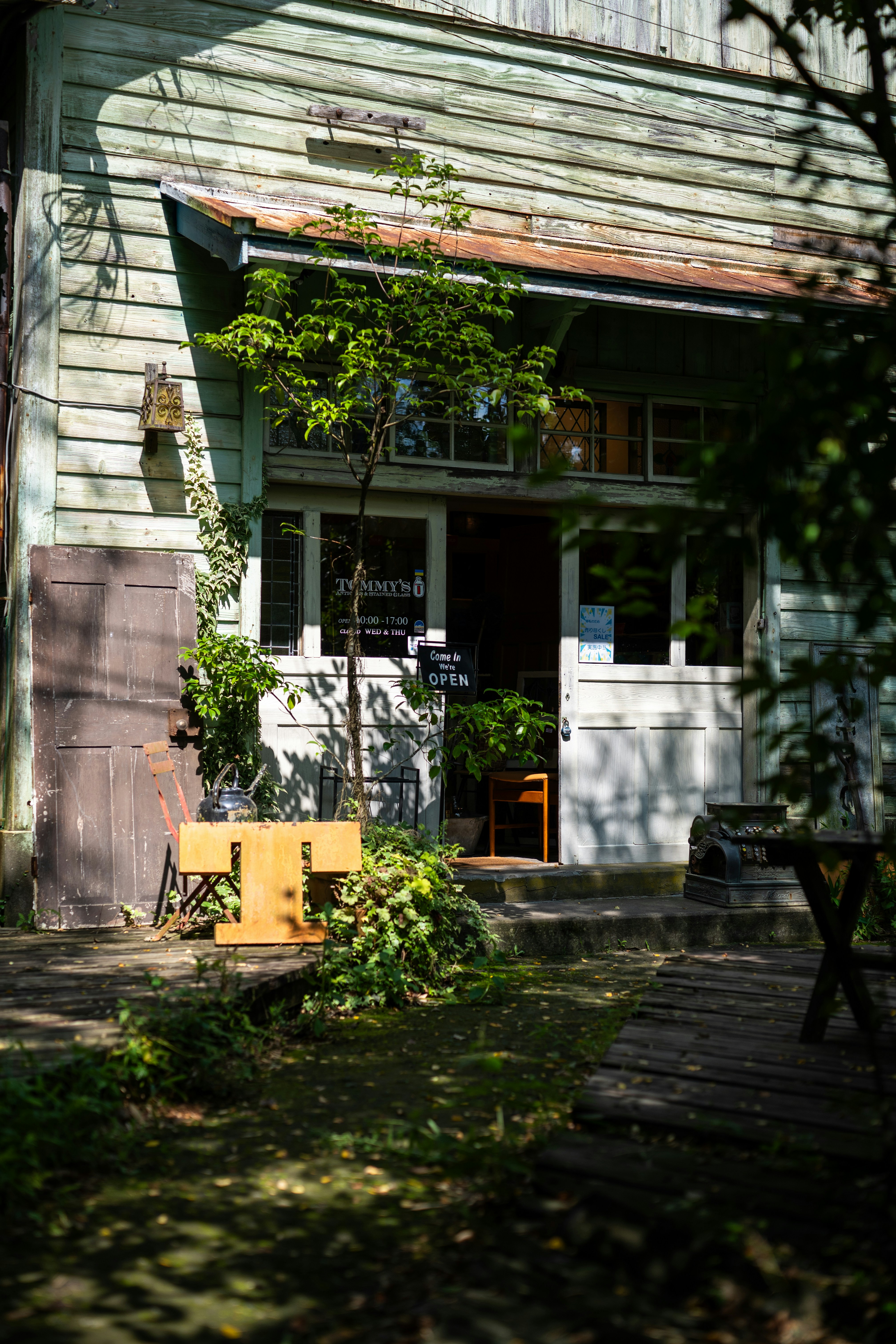 Entrance to a weathered wooden building with plants