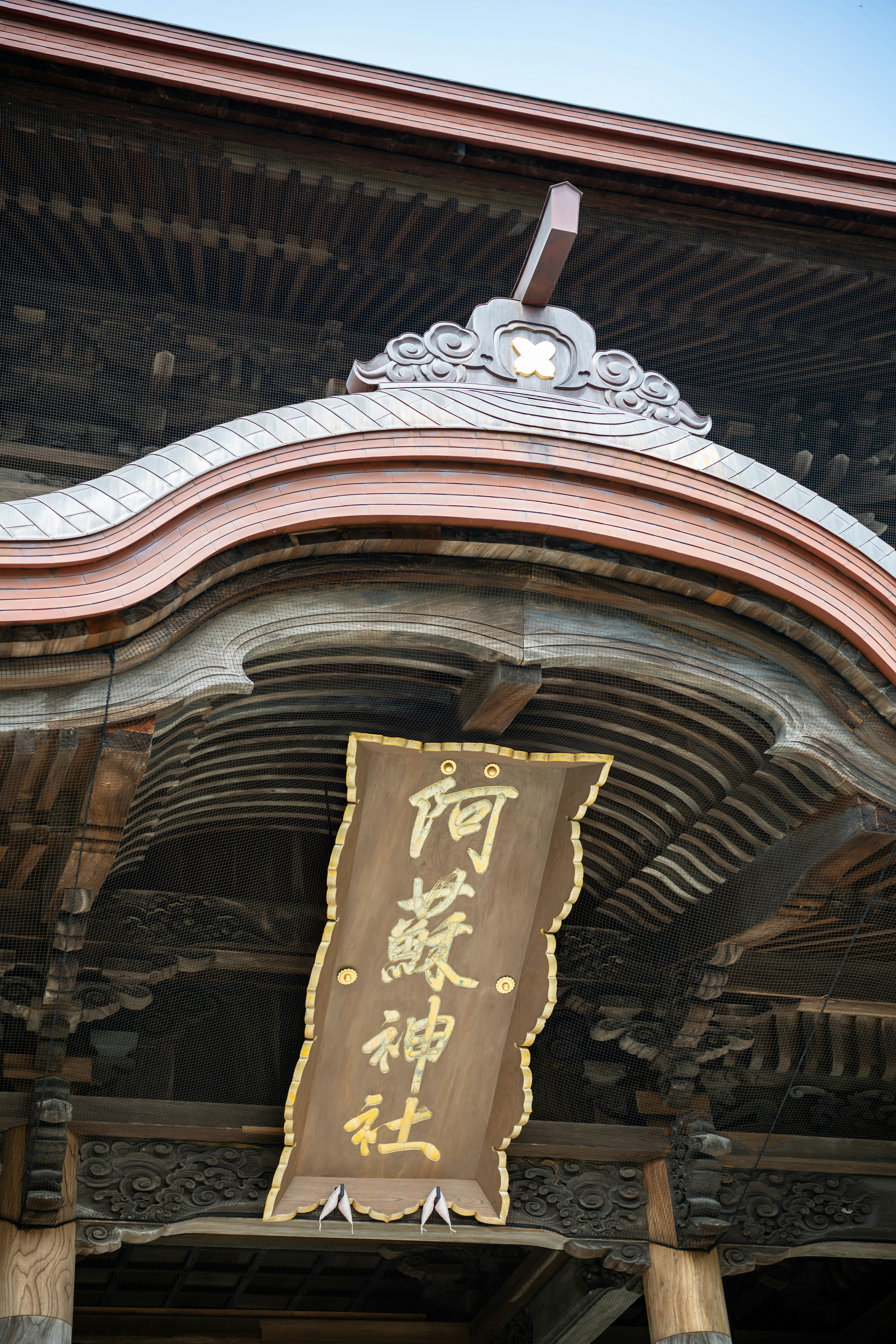 Wooden sign with japanese characters on temple roof