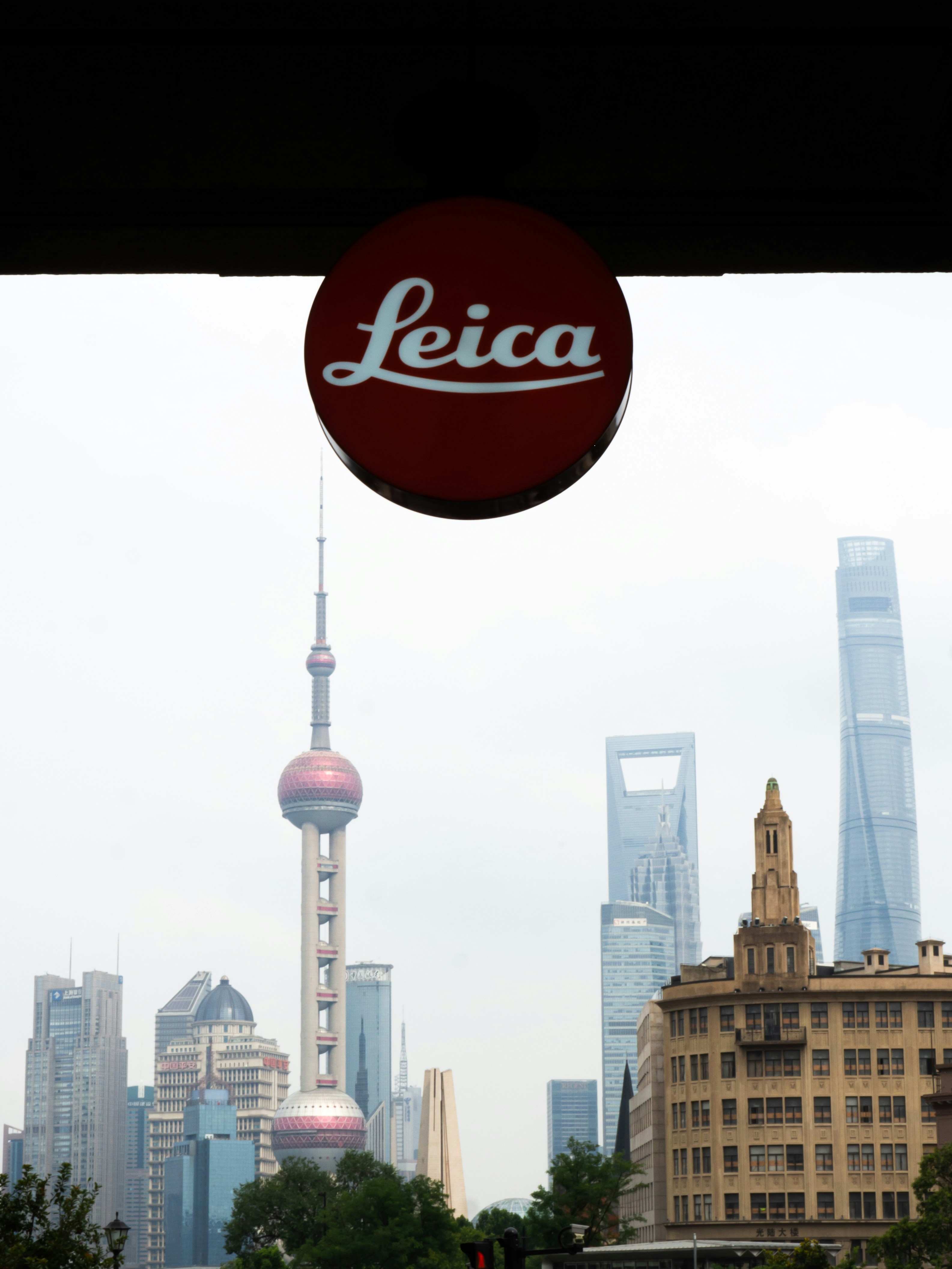 OLYMPUS DIGITAL CAMERA | Leica sign above shanghai skyline with oriental pearl tower