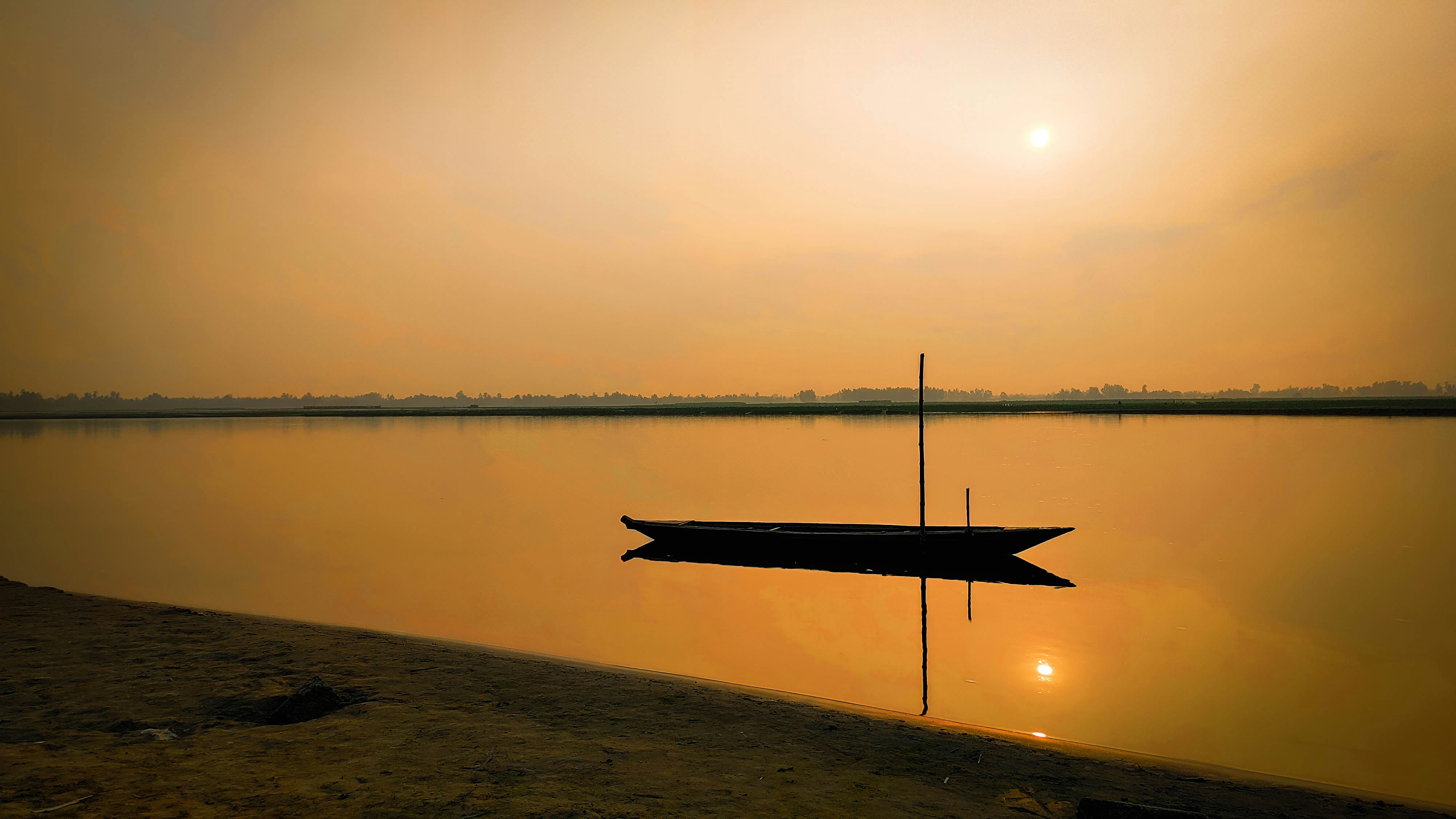 Lonely Boat at Sunset on the River | Small boat floats on calm water during sunset