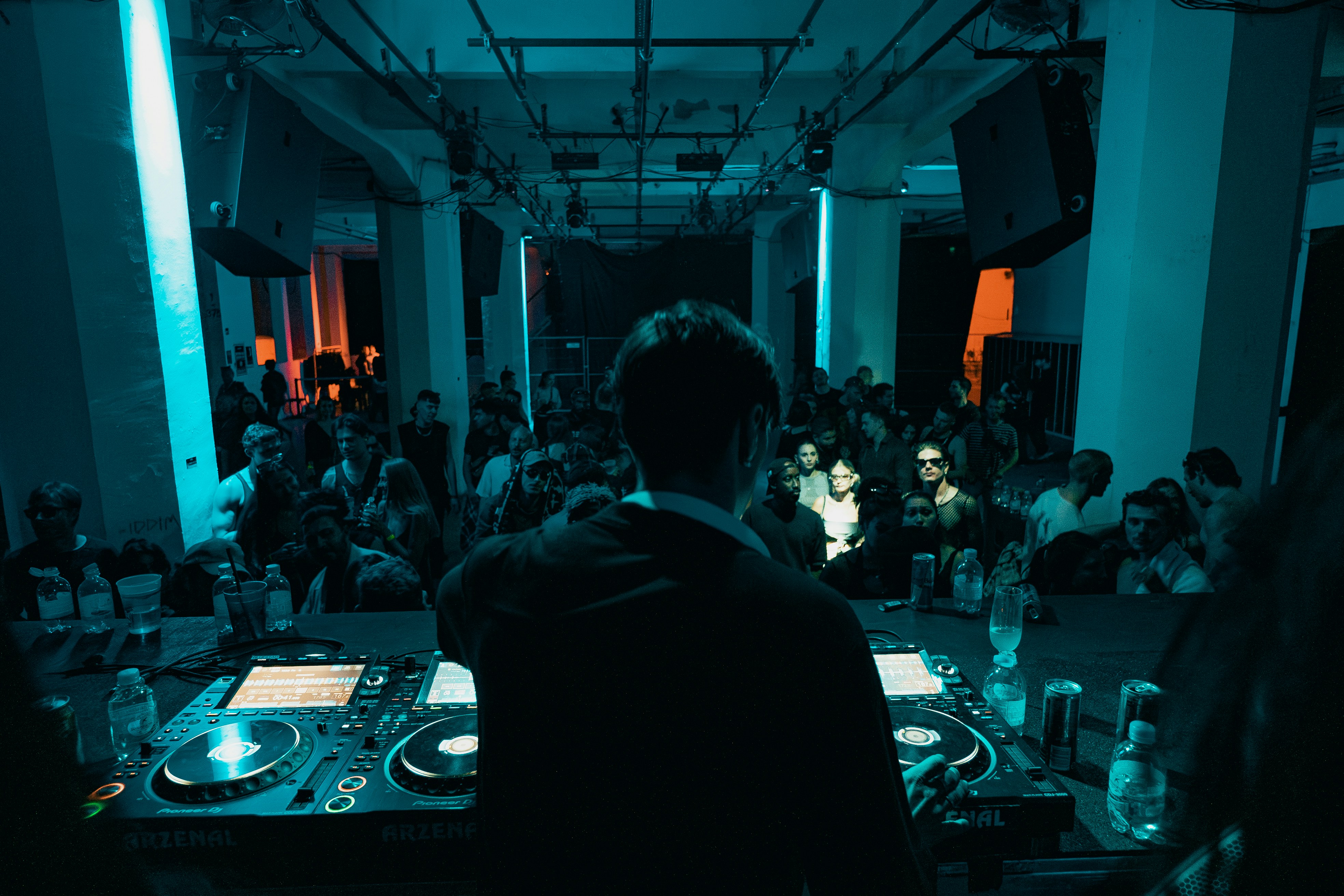 Dj playing music for a crowd in a club.