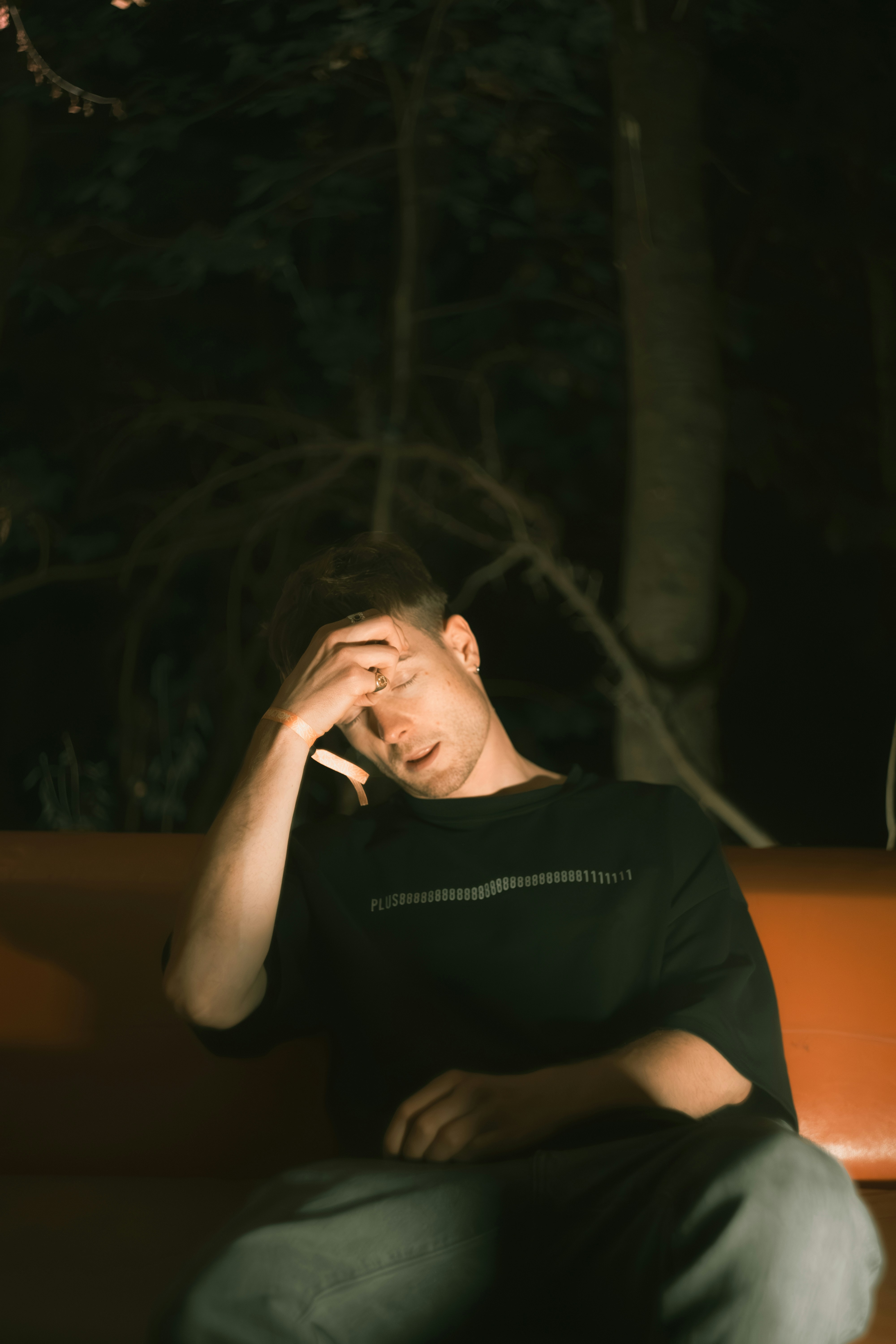 Man holding his head while smoking a cigarette